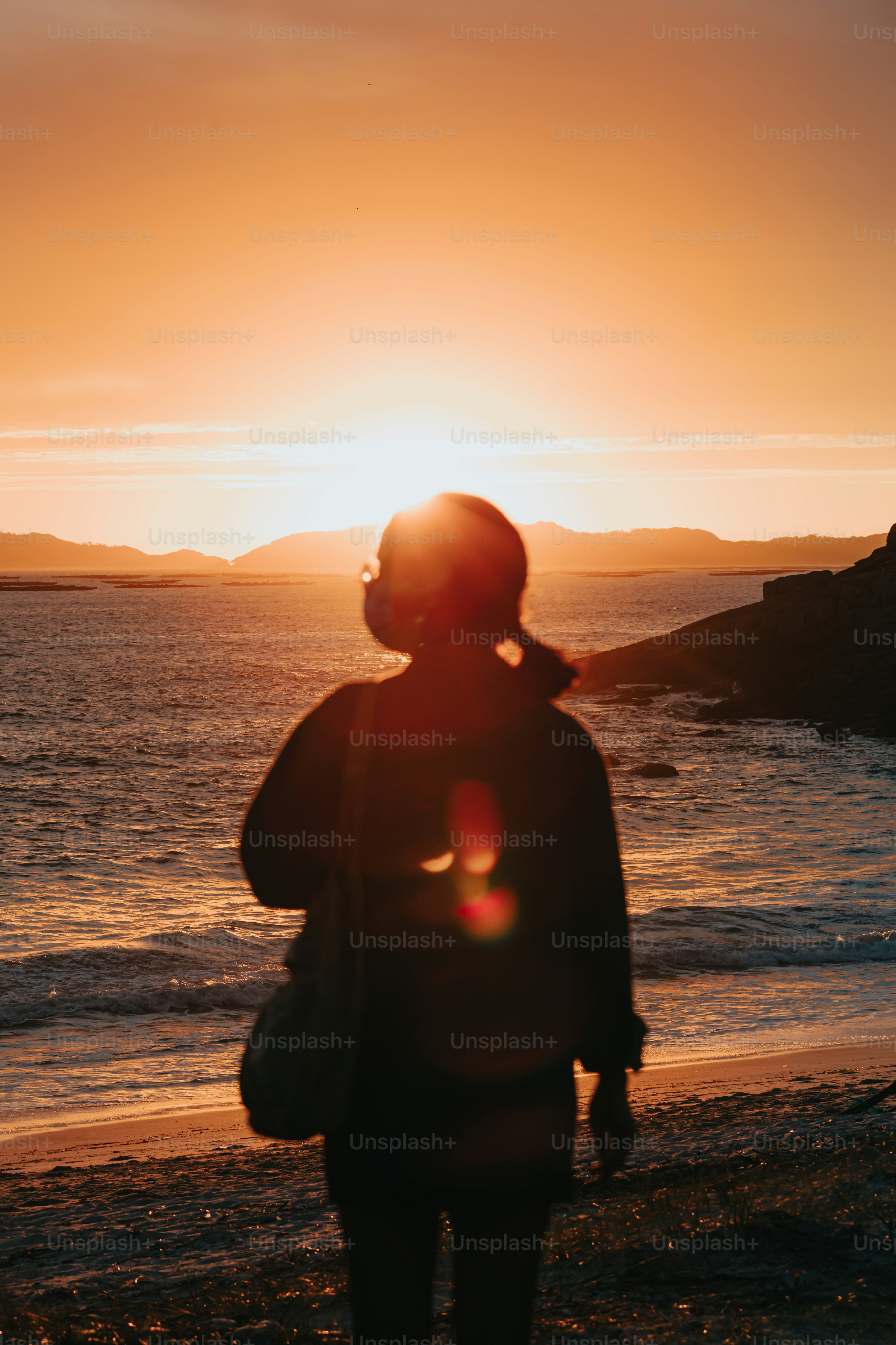 Foto Una persona parada en una playa al atardecer – Mujer Imagen en ...