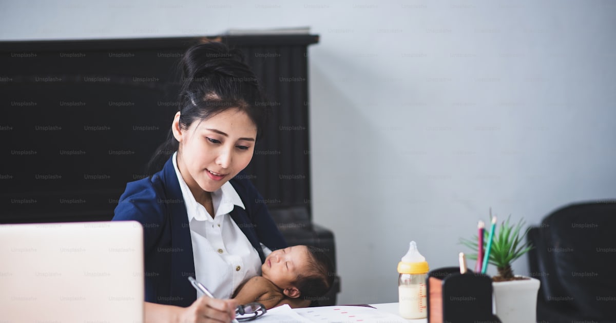 바쁜 젊은 여성이 집에서 아기를 팔에 안고 노트북 컴퓨터로 일하거나 공부하고 있다 사진 Unsplash의 랩톱 이미지