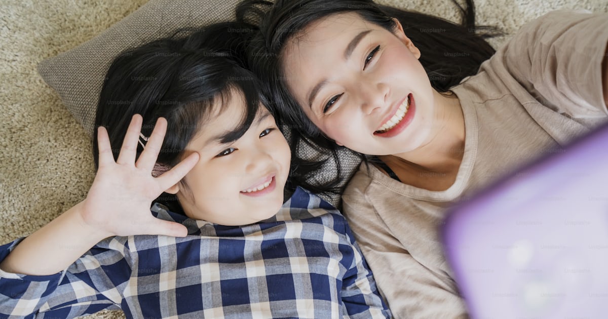 행복한 아시아 가족 어머니와 딸이 거실 집 배경에서 사용하는 동안 셀카 사진을 만들고 있다 사진 Unsplash의 공생 이미지
