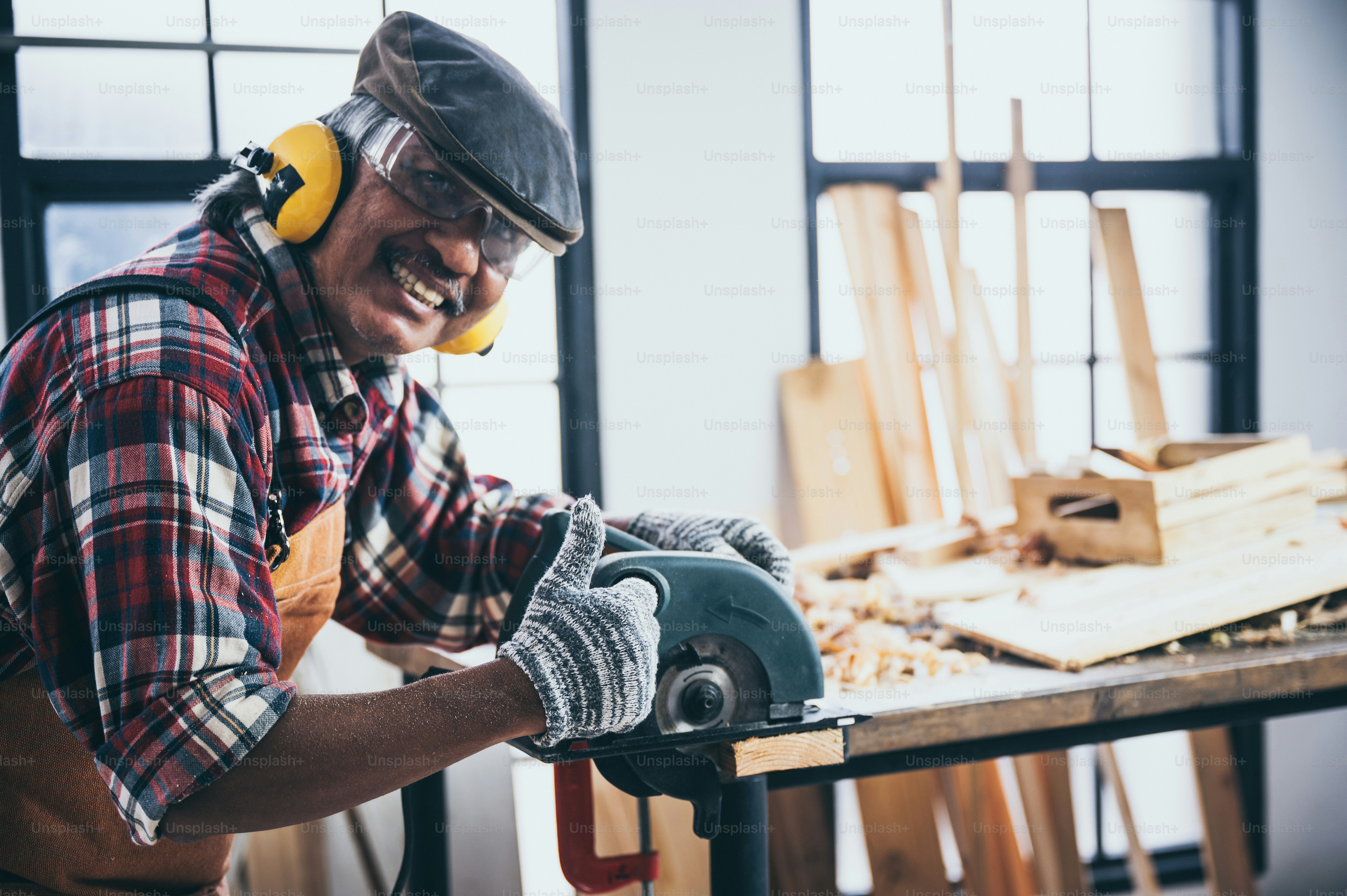 Close-up of a carpenter using a circular saw to cut a large board of ...