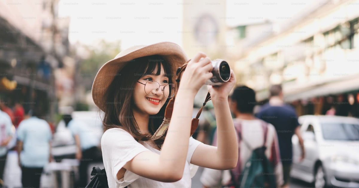 젊은 아시아 귀여운 안경 소녀 힙 스터 스타일 여행자 배낭 솔로 지역 여행은 카메라로 사진을 찍습니다 카오산 도로 거리