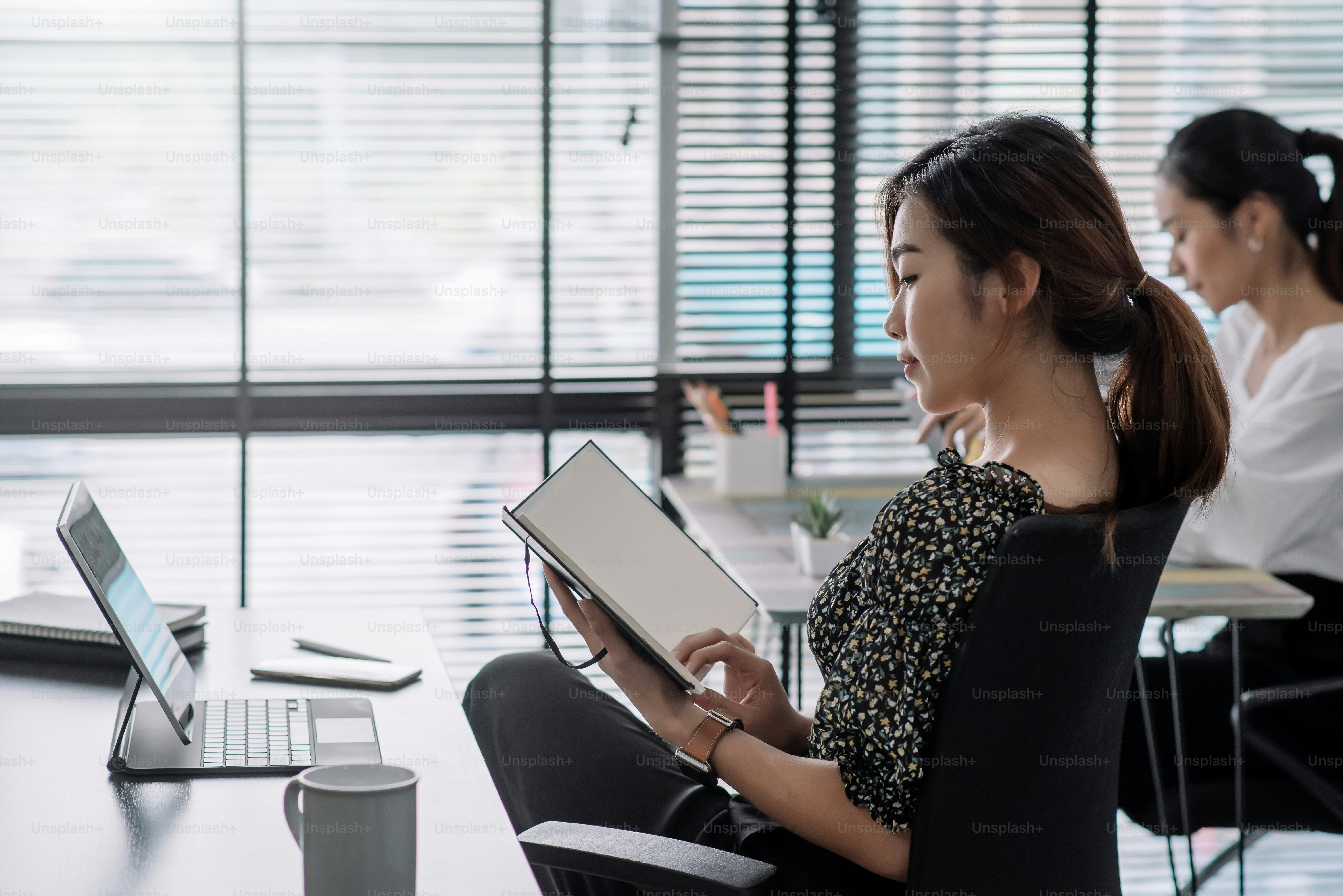 Office worker, beautiful asian woman sitting reading a book or document ...