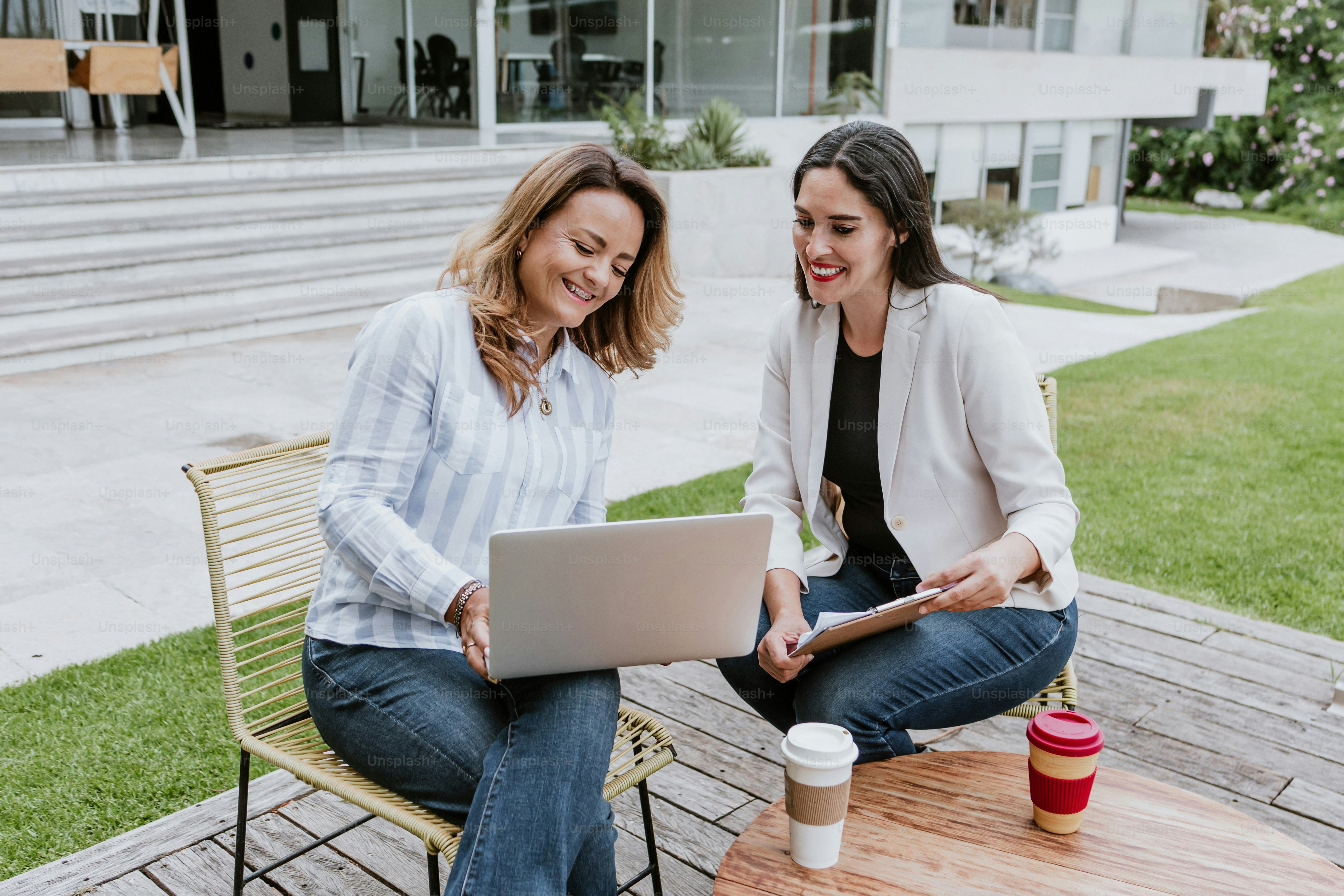 Two latin business woman middle age, talking and advising each other at ...