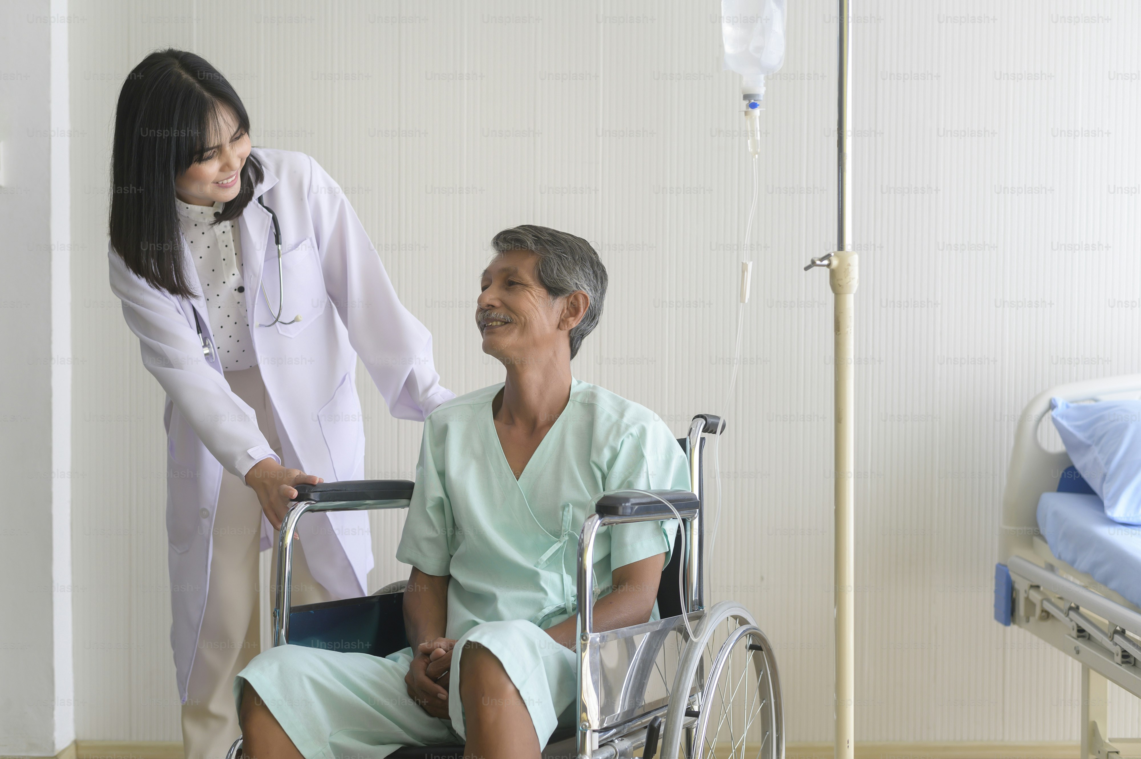 Foto Médico que ayuda a un paciente mayor a trasladarse a sillas de ...