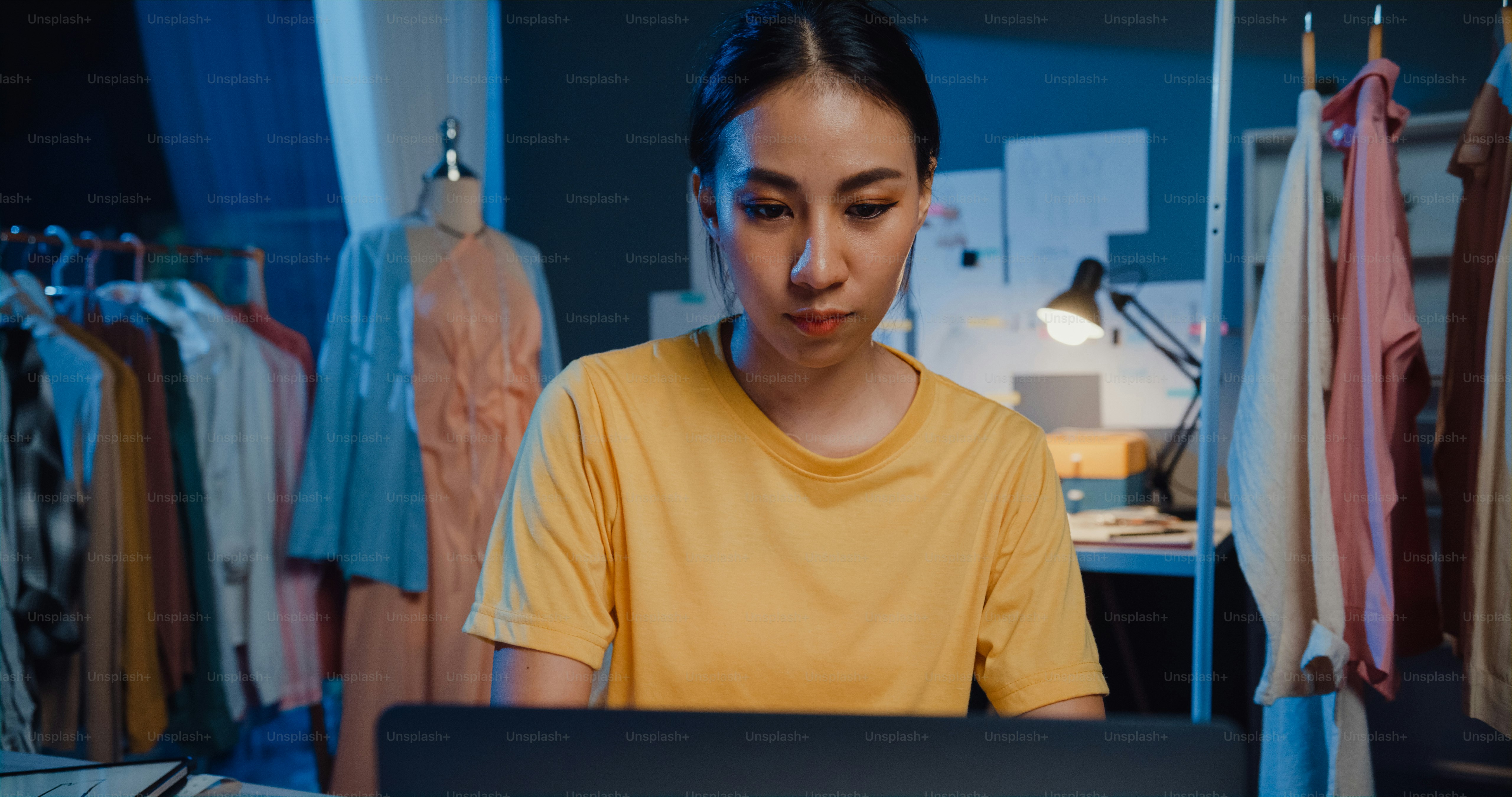 Professional Asia female fashion designer with casual use laptop ...