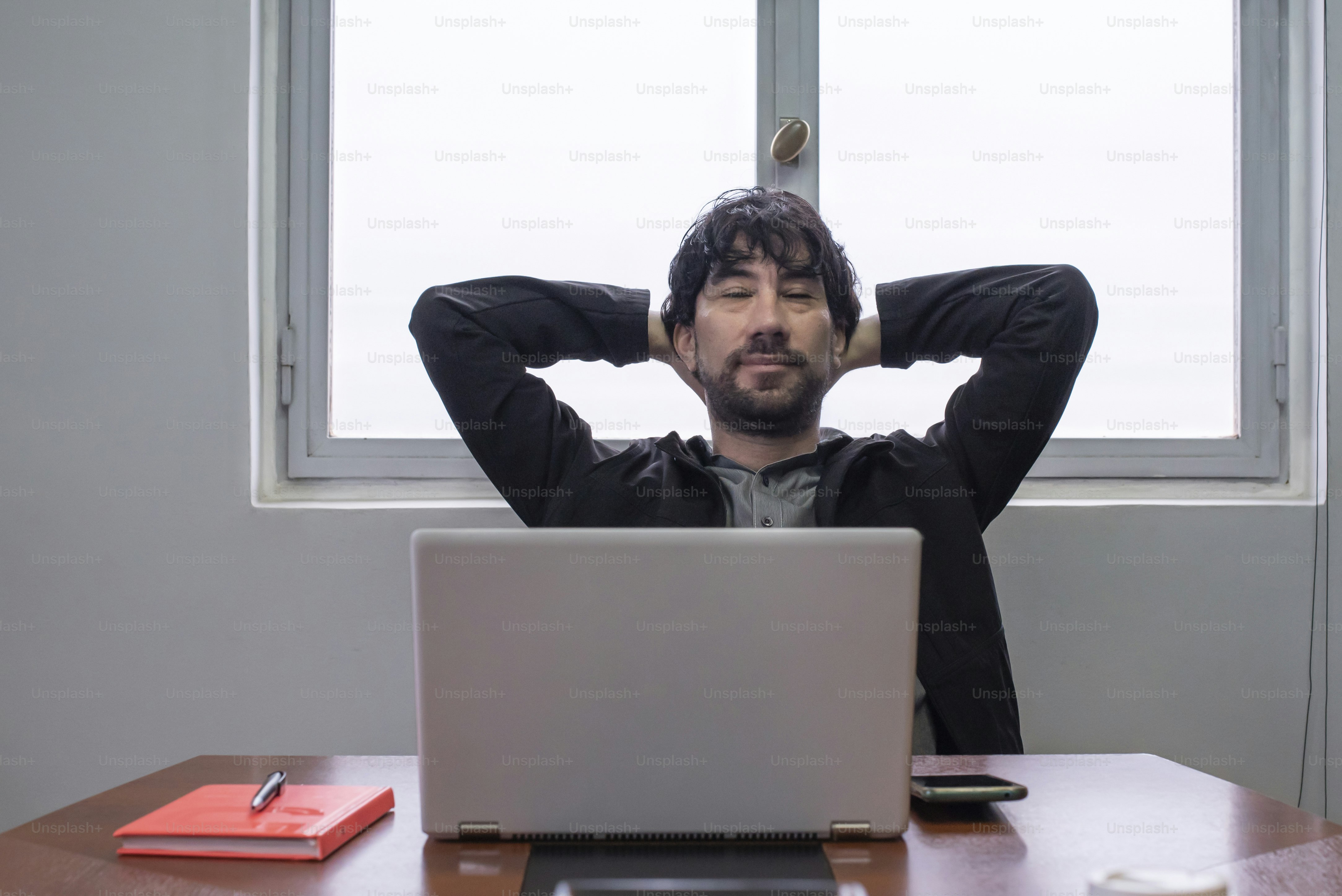 Relaxed businessman at the work desk, positive calm, holding hands ...