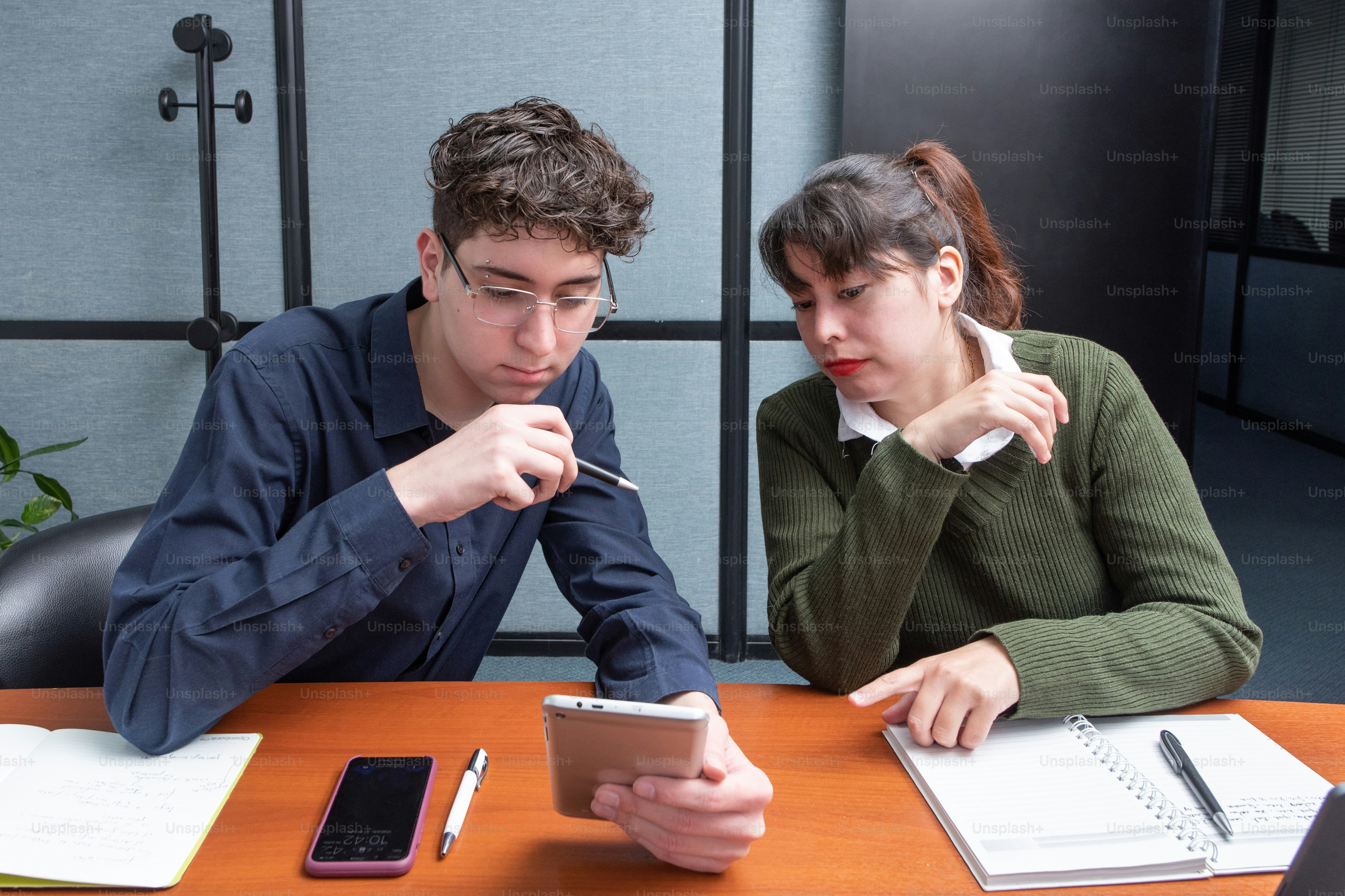 Two young colleagues working together in the office photo – Communicate ...