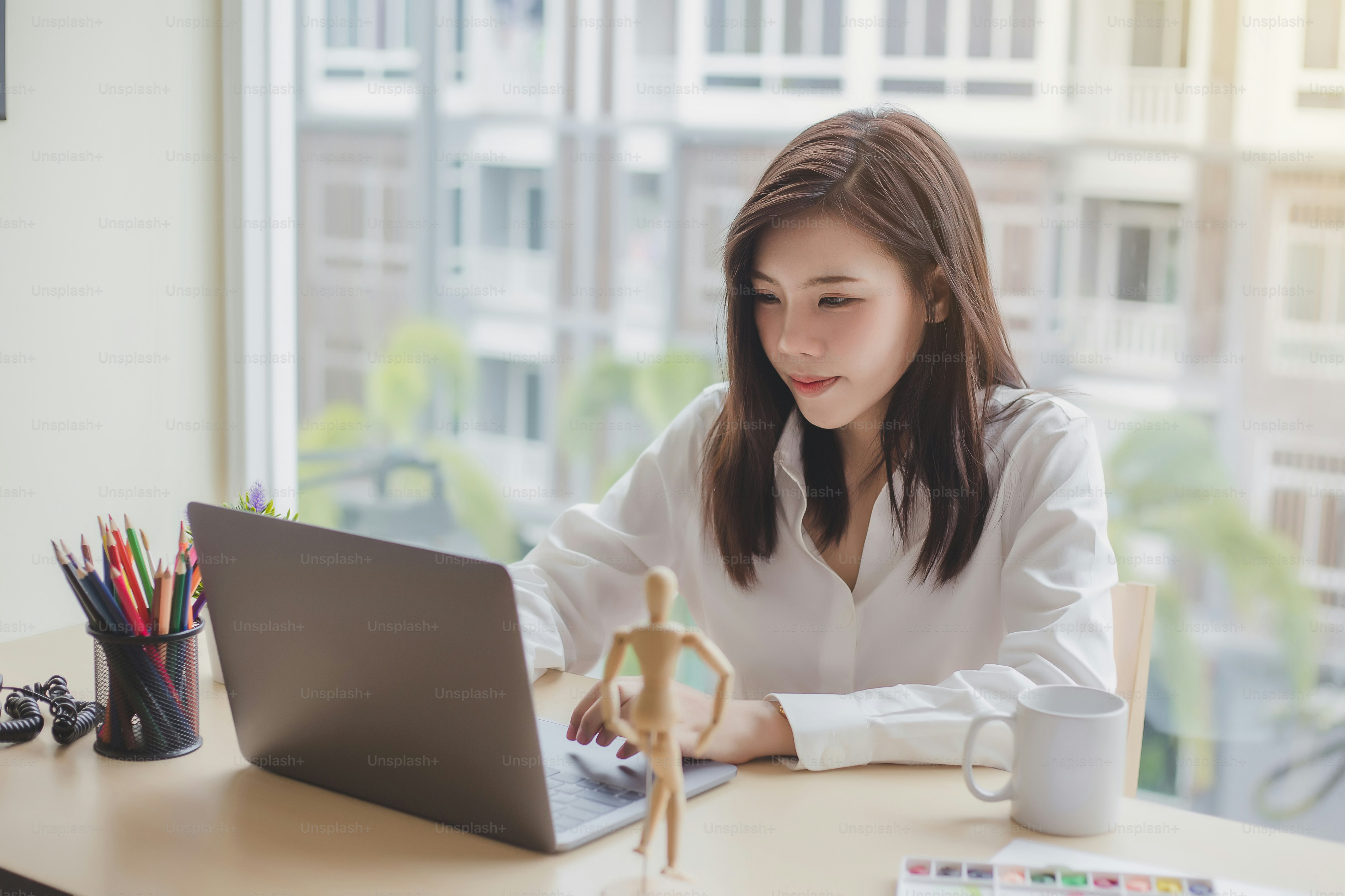 Young woman graphic designer working on laptop and computer in the ...
