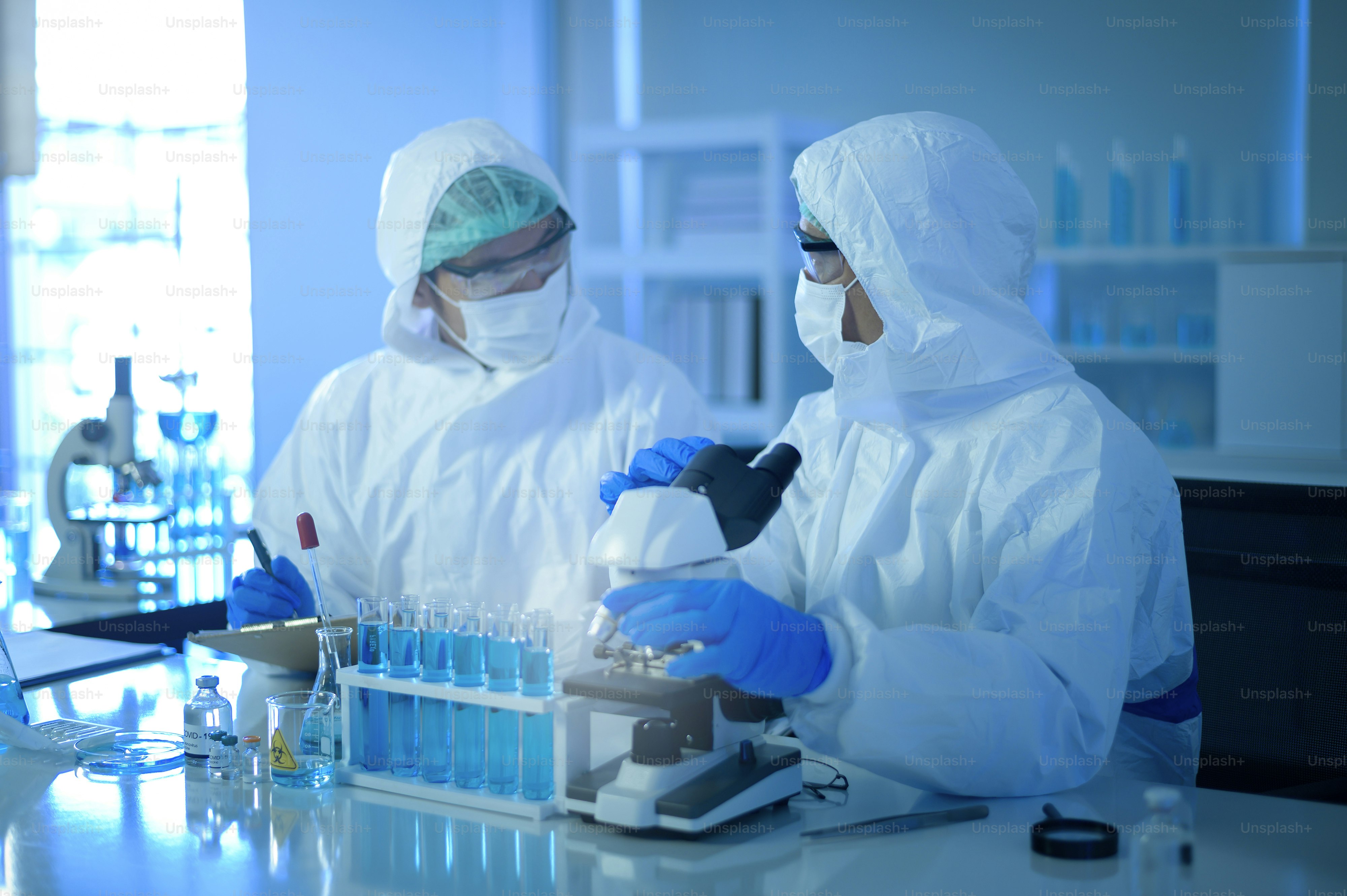 A scientist using microscope during experiment in laboratory, Science ...