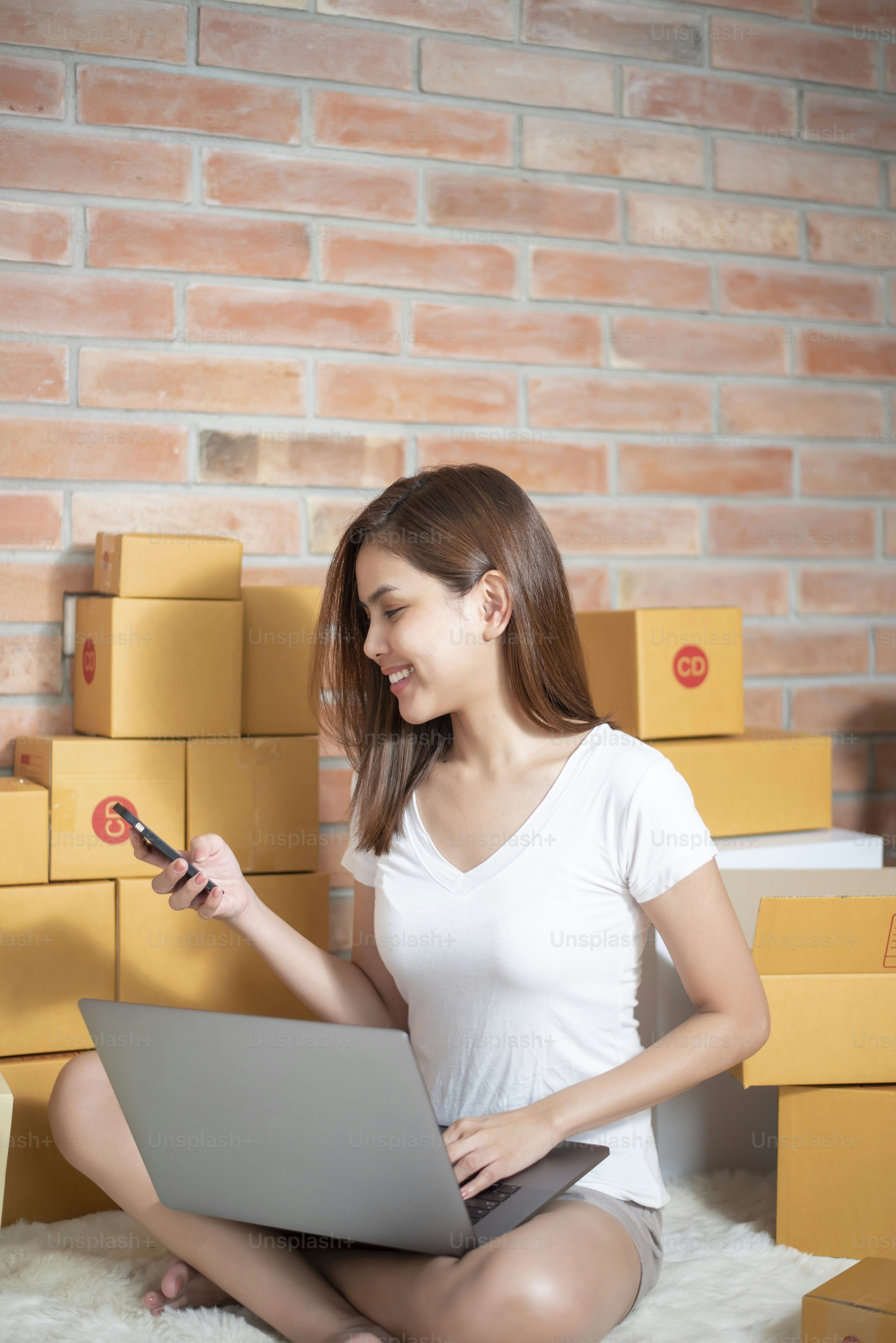 La empresaria propietaria de una empresa de pymes está verificando el pedido con un teléfono ...