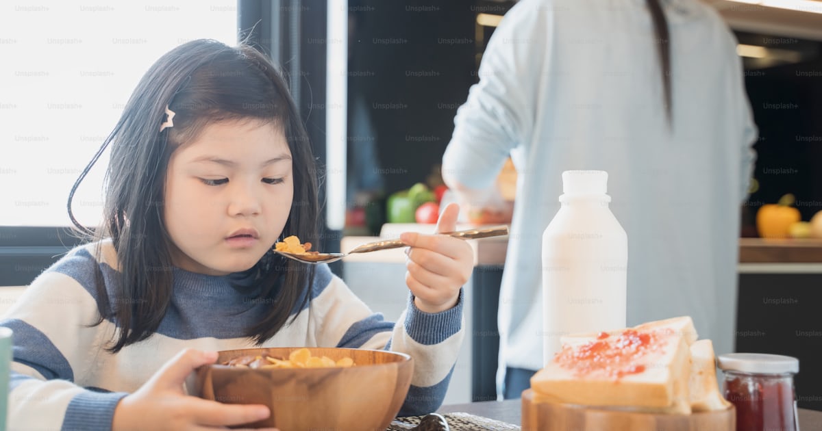 엄마와 딸은 부엌에서 아침 식사를 하는 우유와 함께 시리얼을 먹고 있다 사진 Unsplash의 초상 이미지