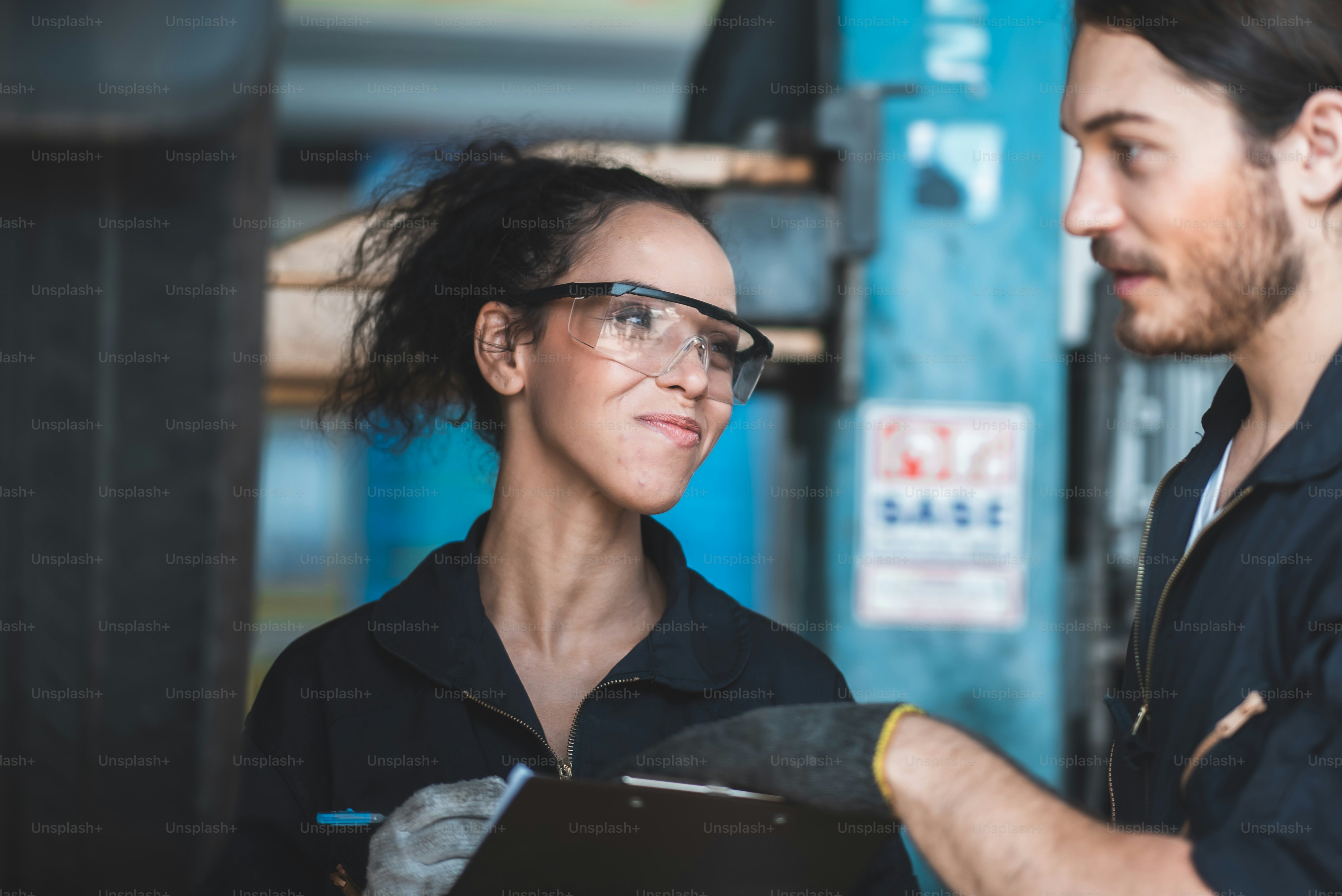 Male and female machanic wearing uniform doing automoblie checklist ...