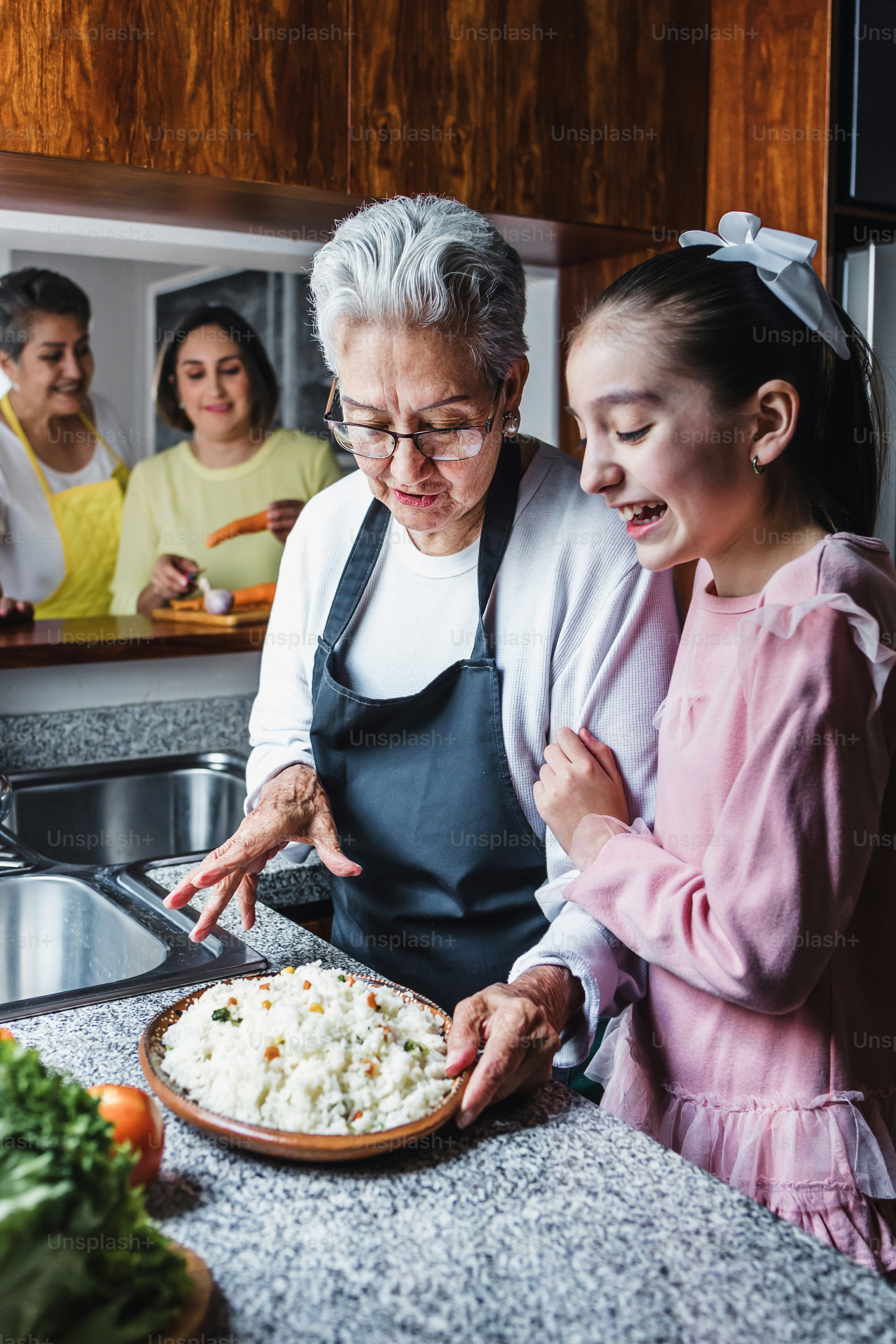 Hispanic women grandmother and granddaughter cooking at home kitchen in ...