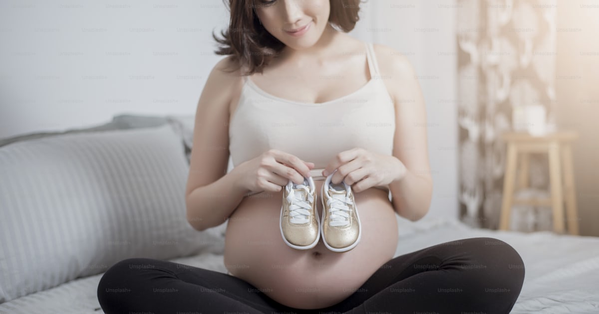 아름 다운 아시아 임신 한 여자는 작은 신발로 아기를 기대 사진 Unsplash의 임신한 이미지