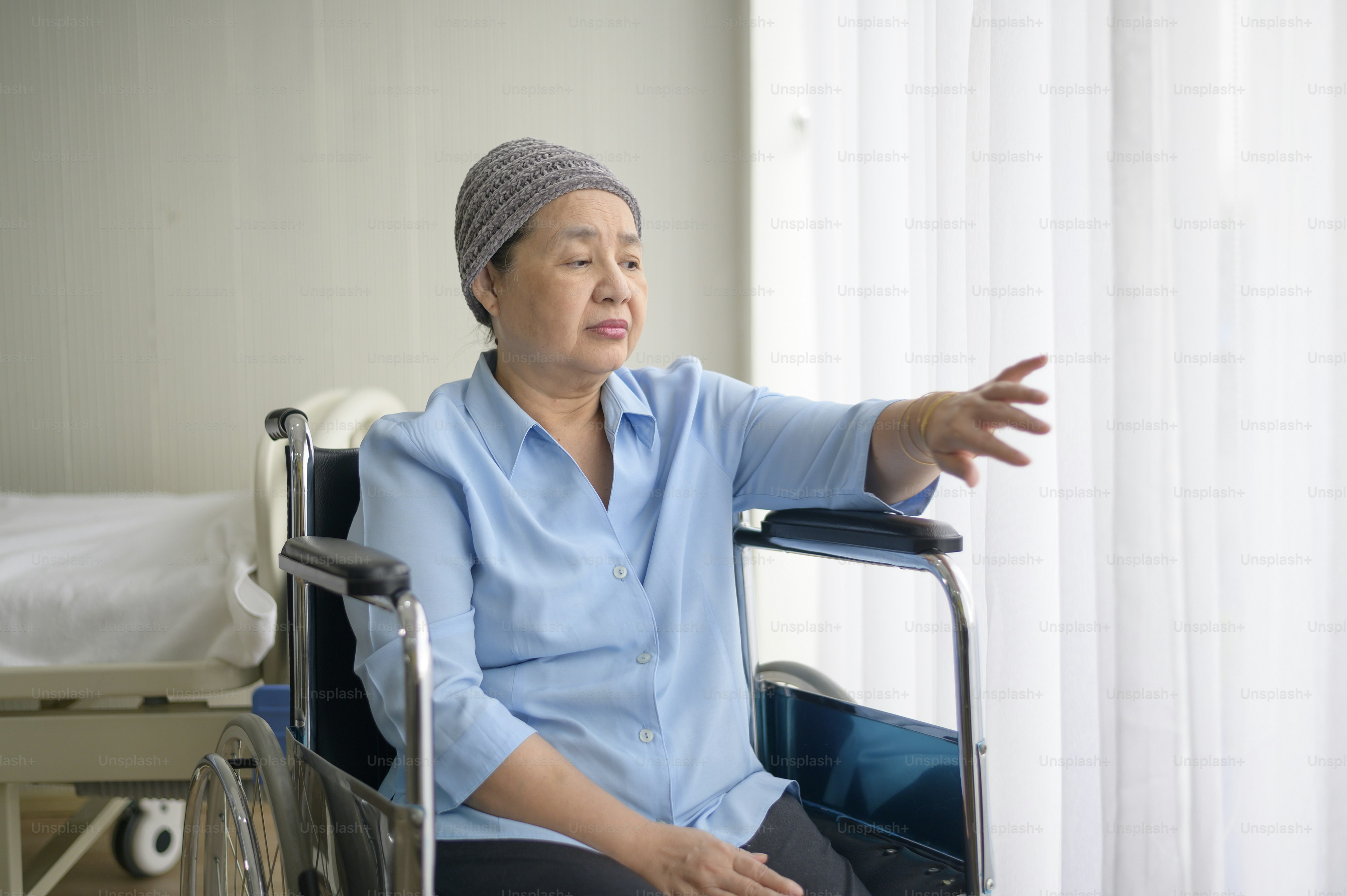 A depressed and hopeless Asian cancer patient woman wearing head scarf ...