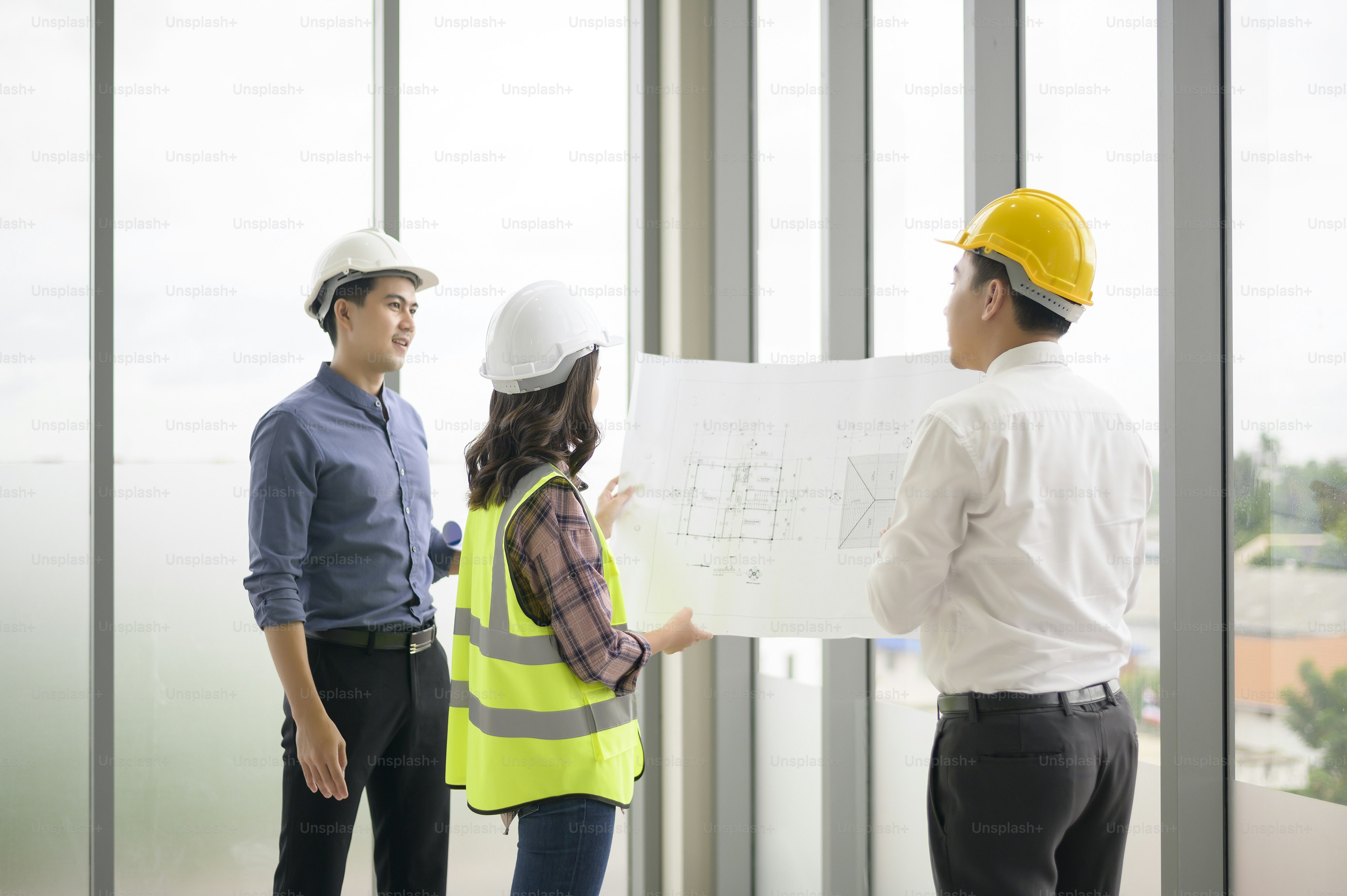 Engineering people are analytics construction plans with blueprint in ...