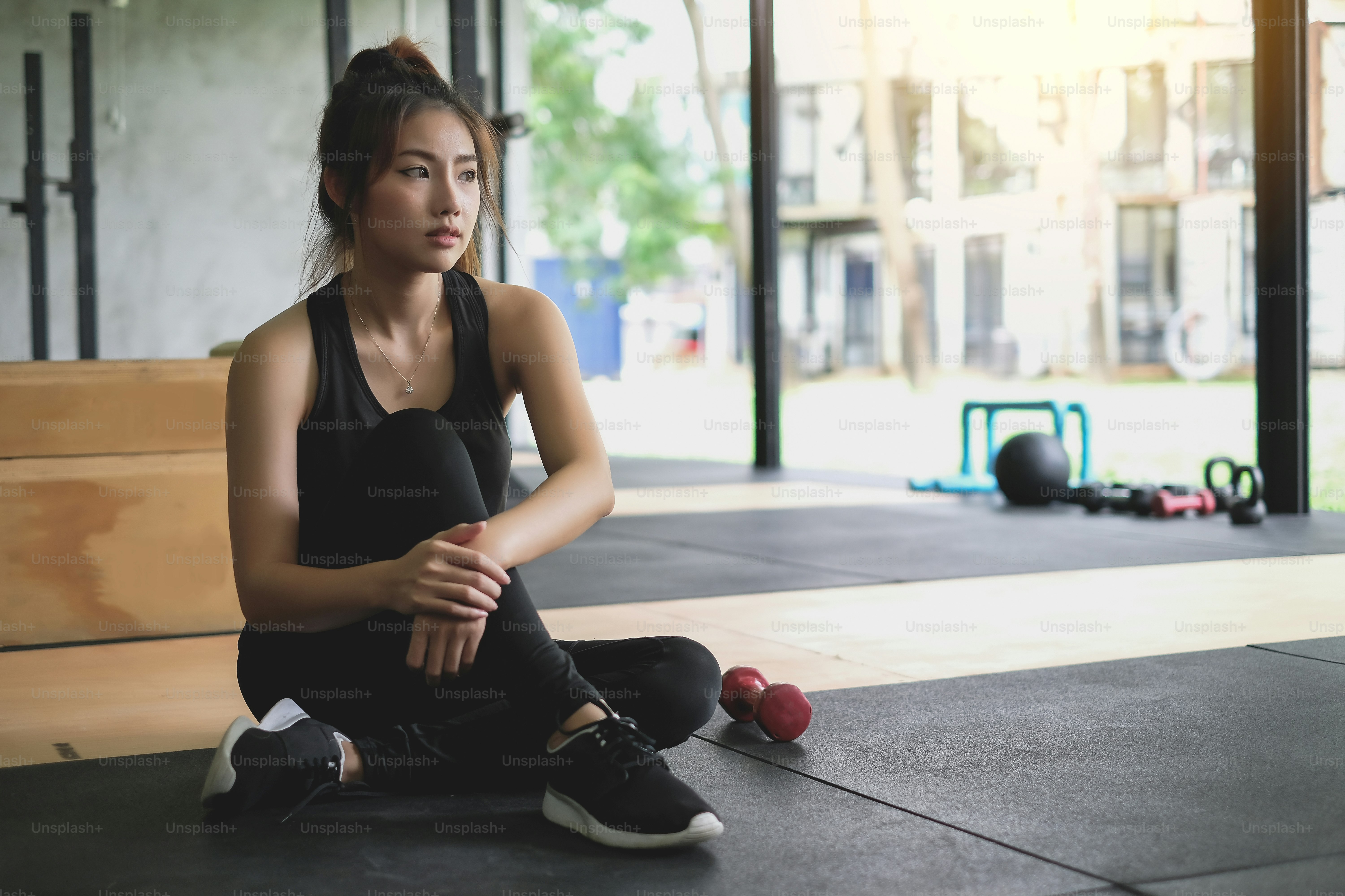 Foto zum Thema Frau sitzt und entspannt sich nach dem Training. – Bild zu Übend auf Unsplash