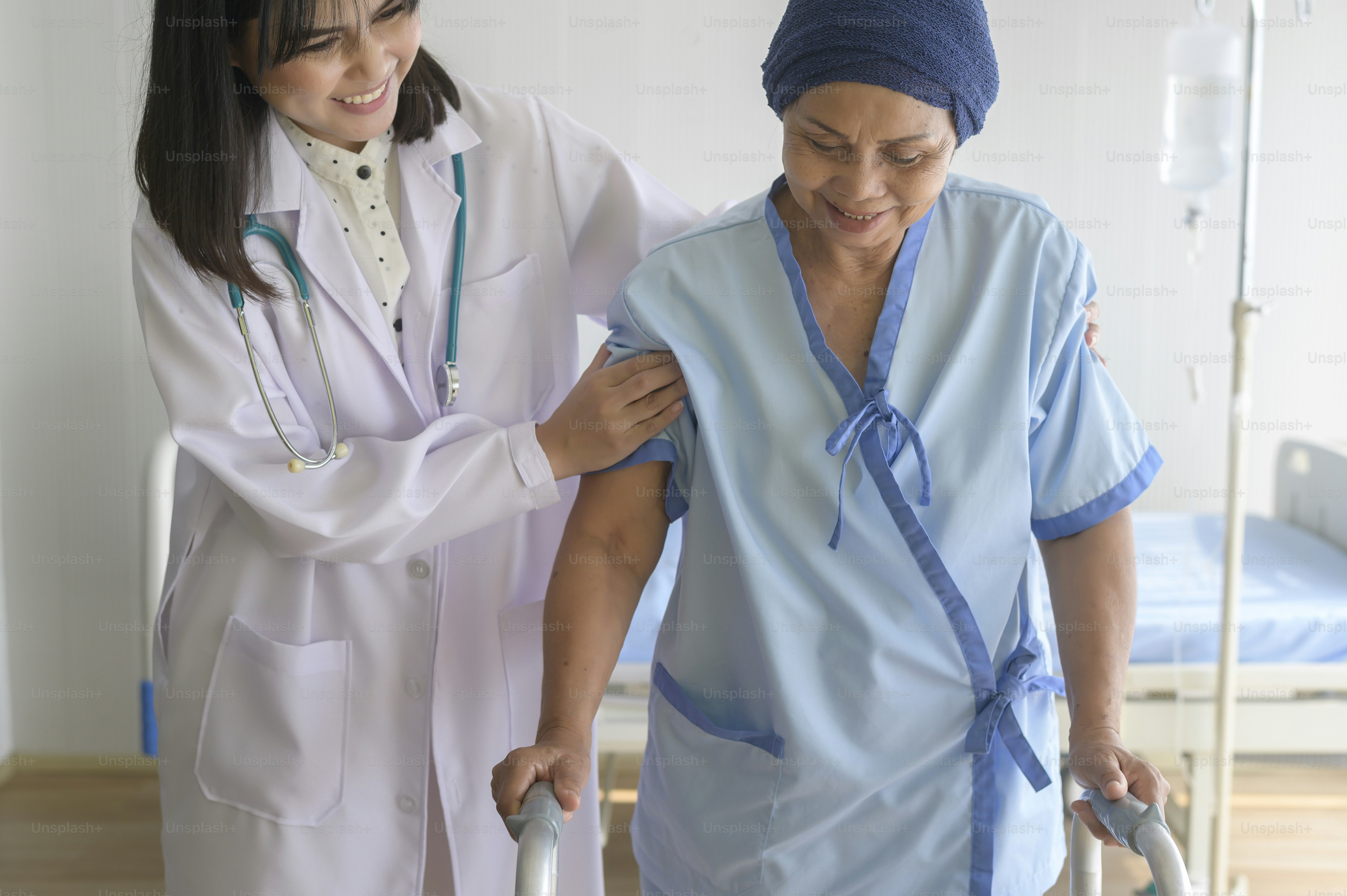 Doctor helping cancer patient woman wearing head scarf with walker at ...