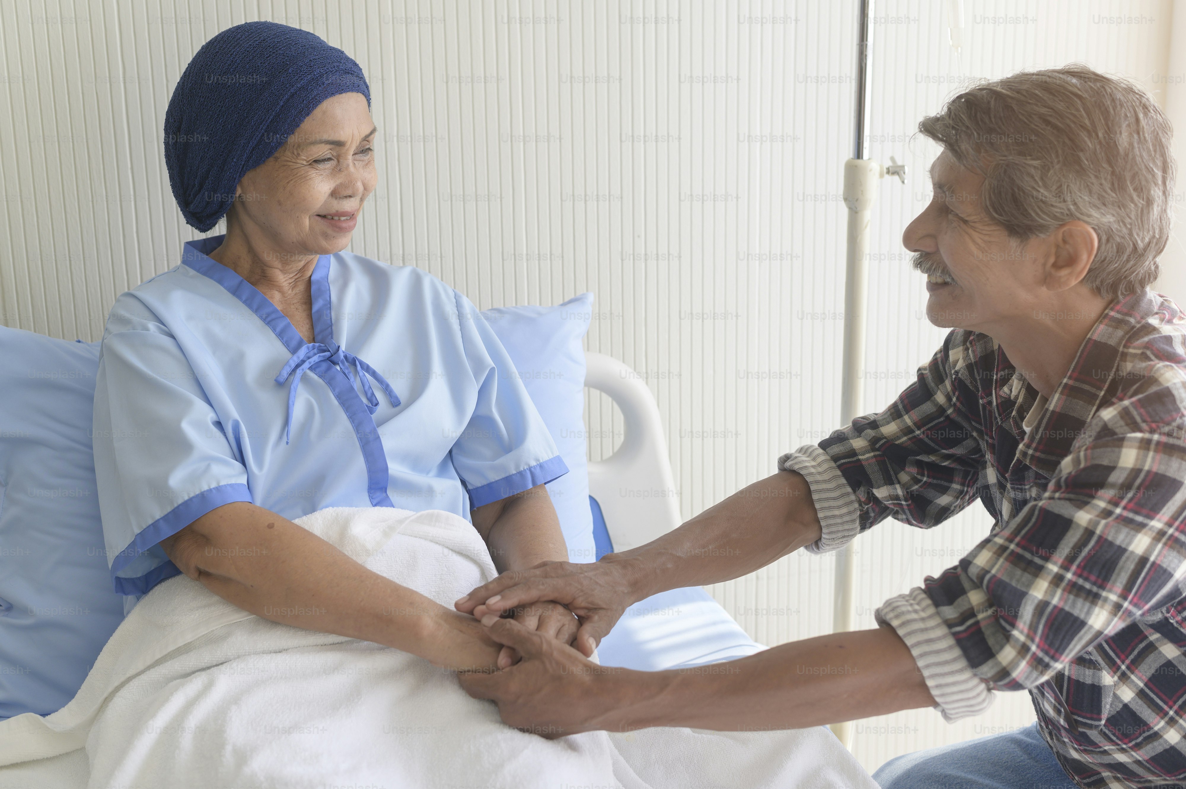 A Senior man visiting cancer patient woman wearing head scarf at ...