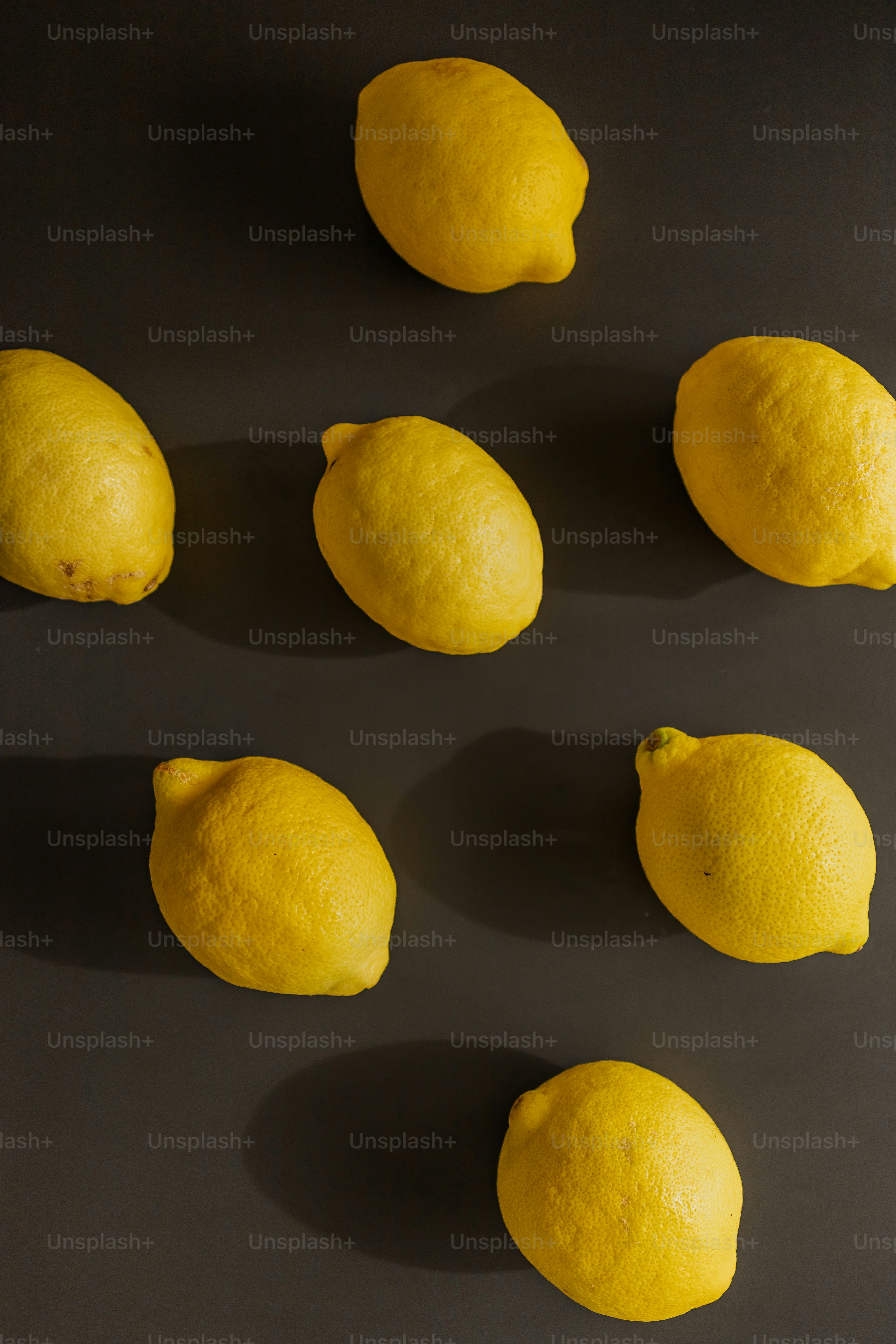 A group of lemons sitting on top of a yellow table photo – Solid yellow ...