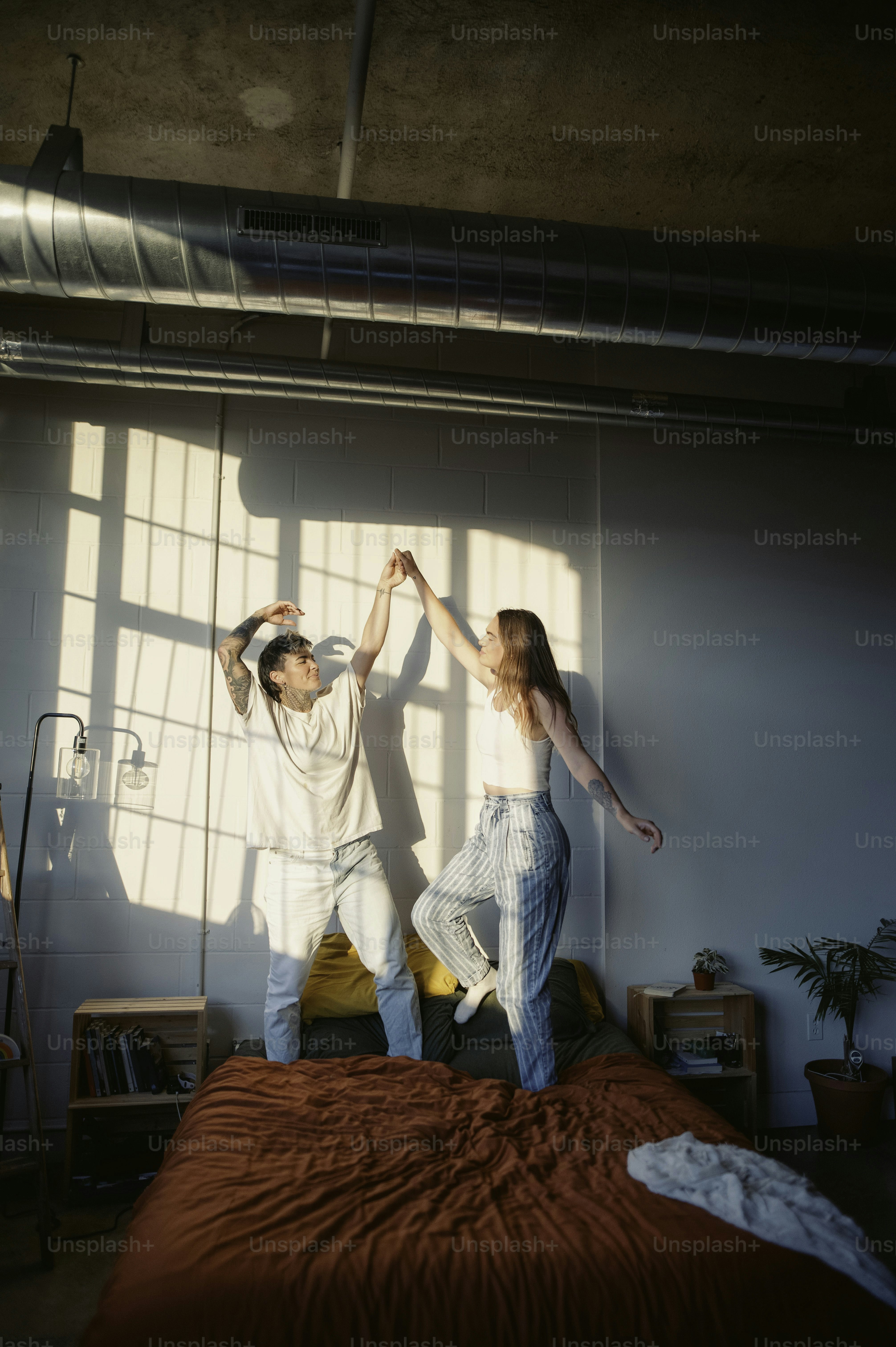 A couple of women standing on top of a bed photo – Lgbt2+ Image on Unsplash
