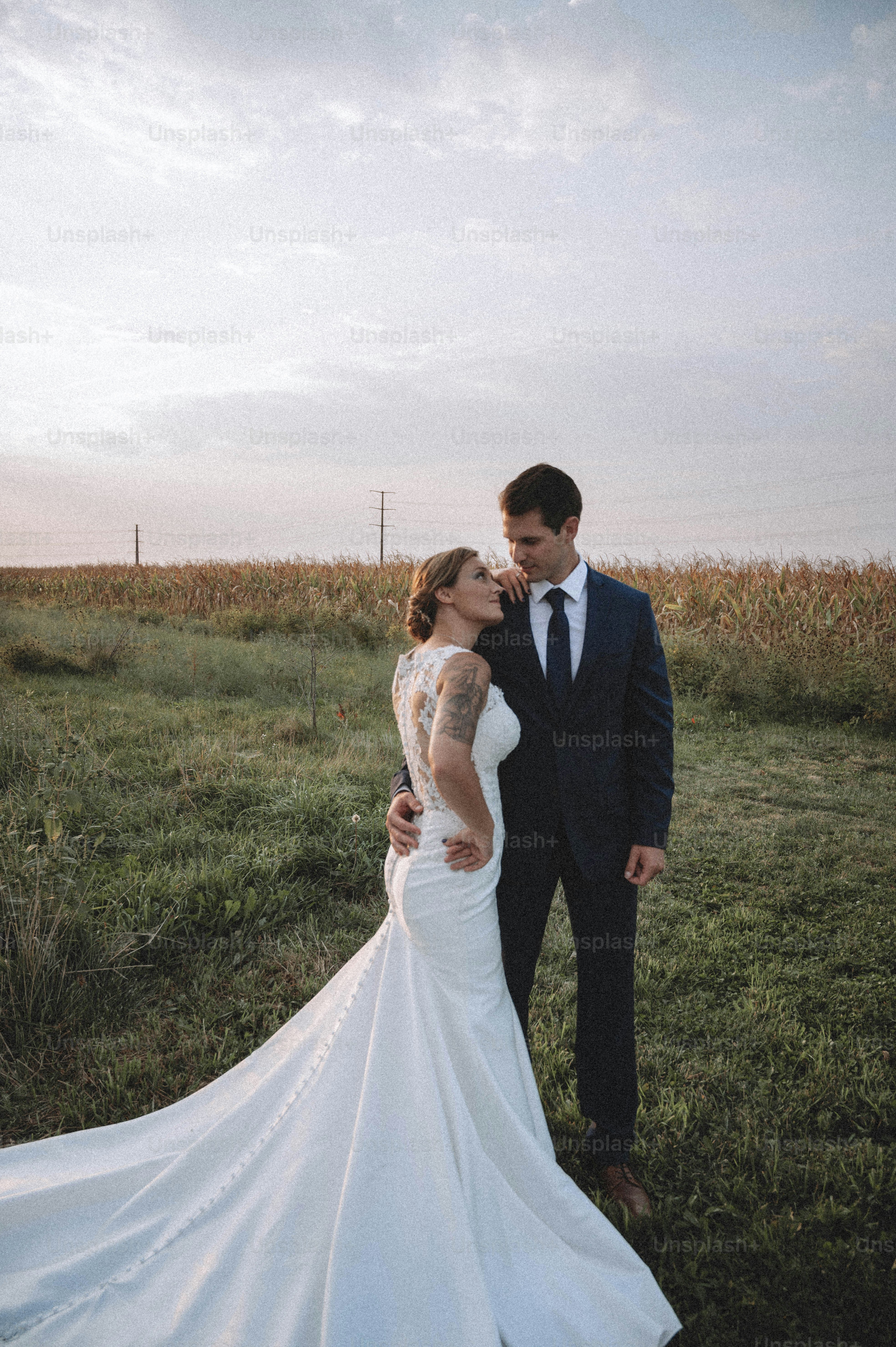 A bride and groom holding hands in a field photo – Wedding Image on ...