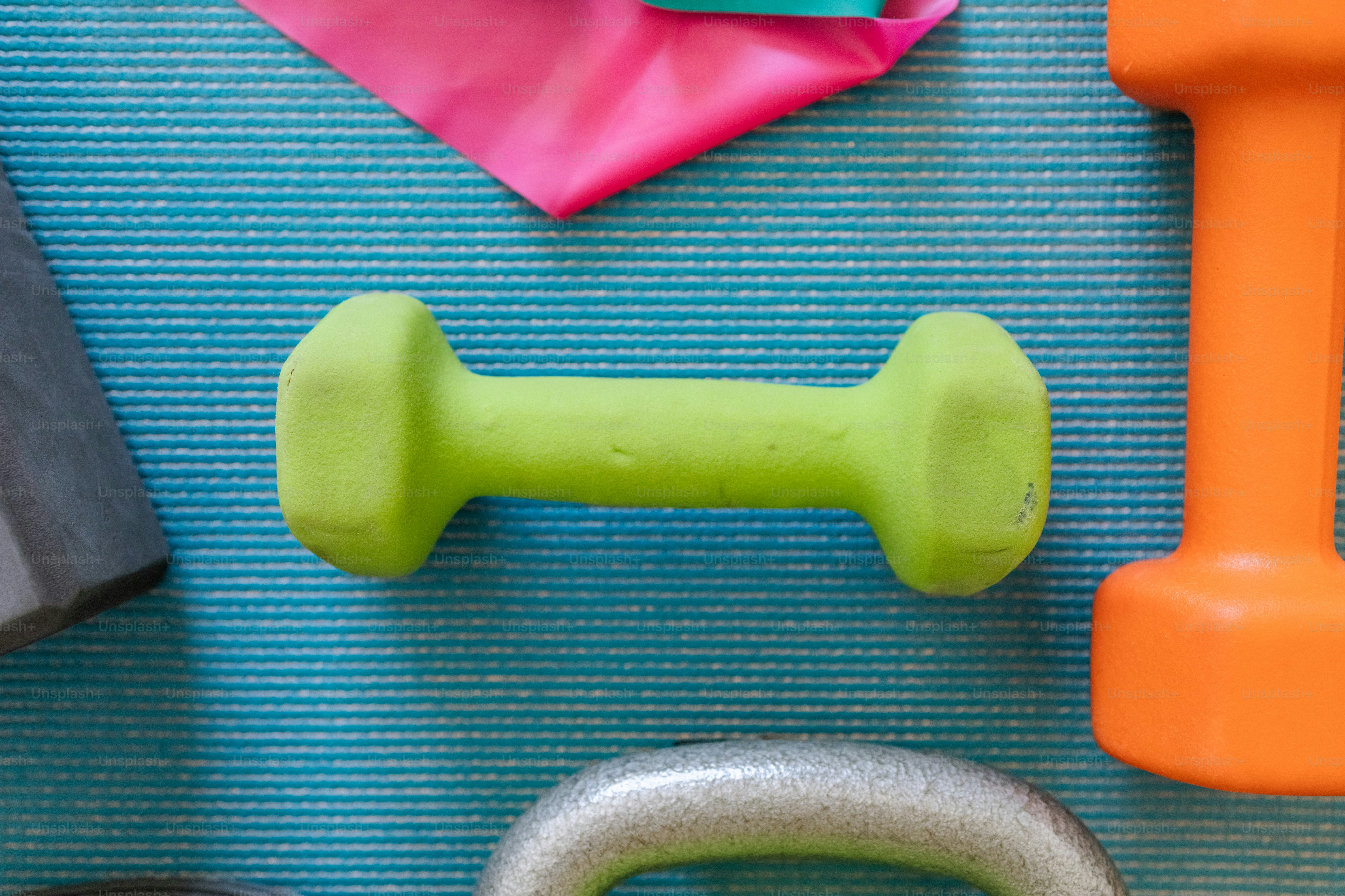 A close up of a gym mat with dumbs, a pair of scissors and photo ...