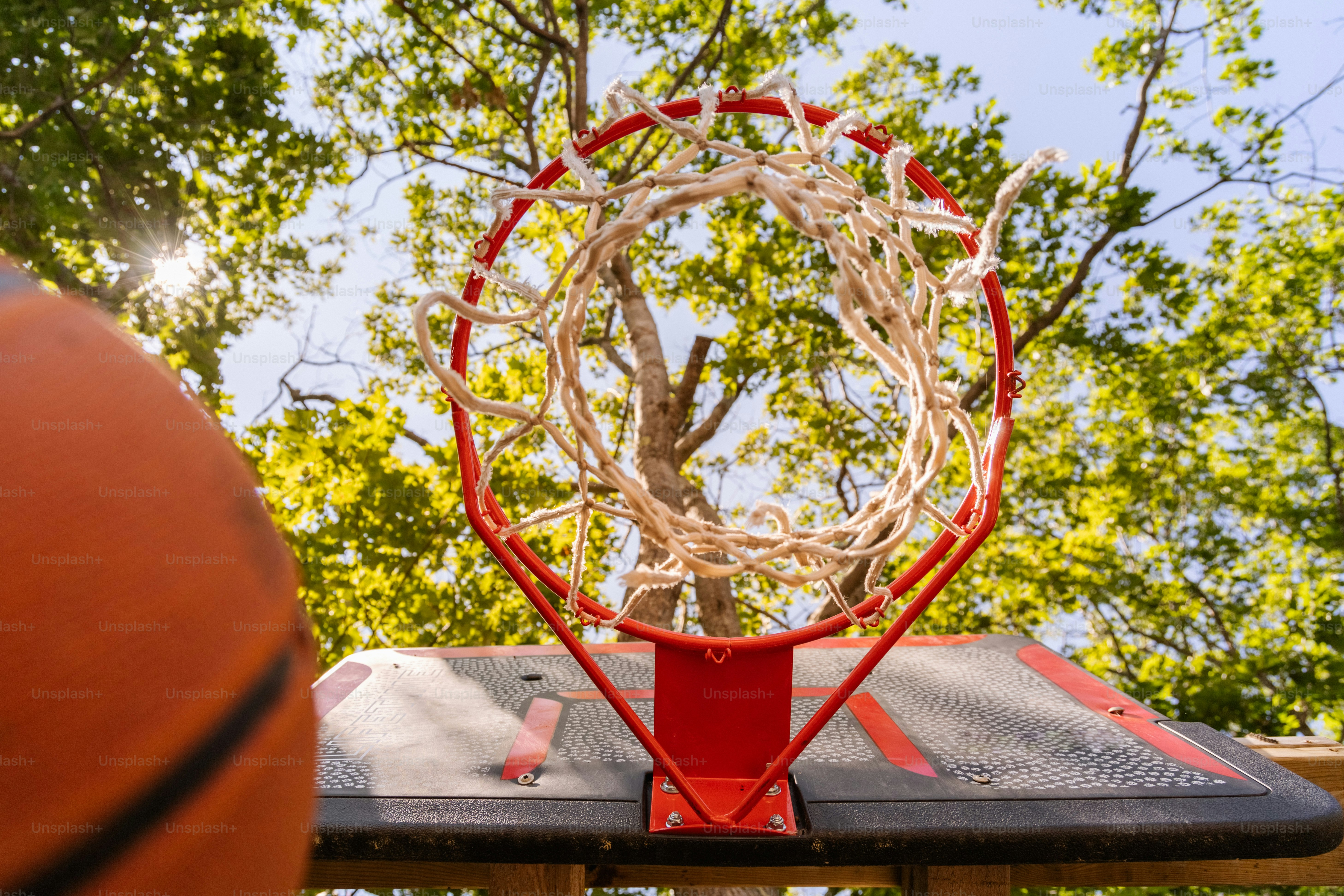 A basketball going through the hoop of a basketball hoop photo ...