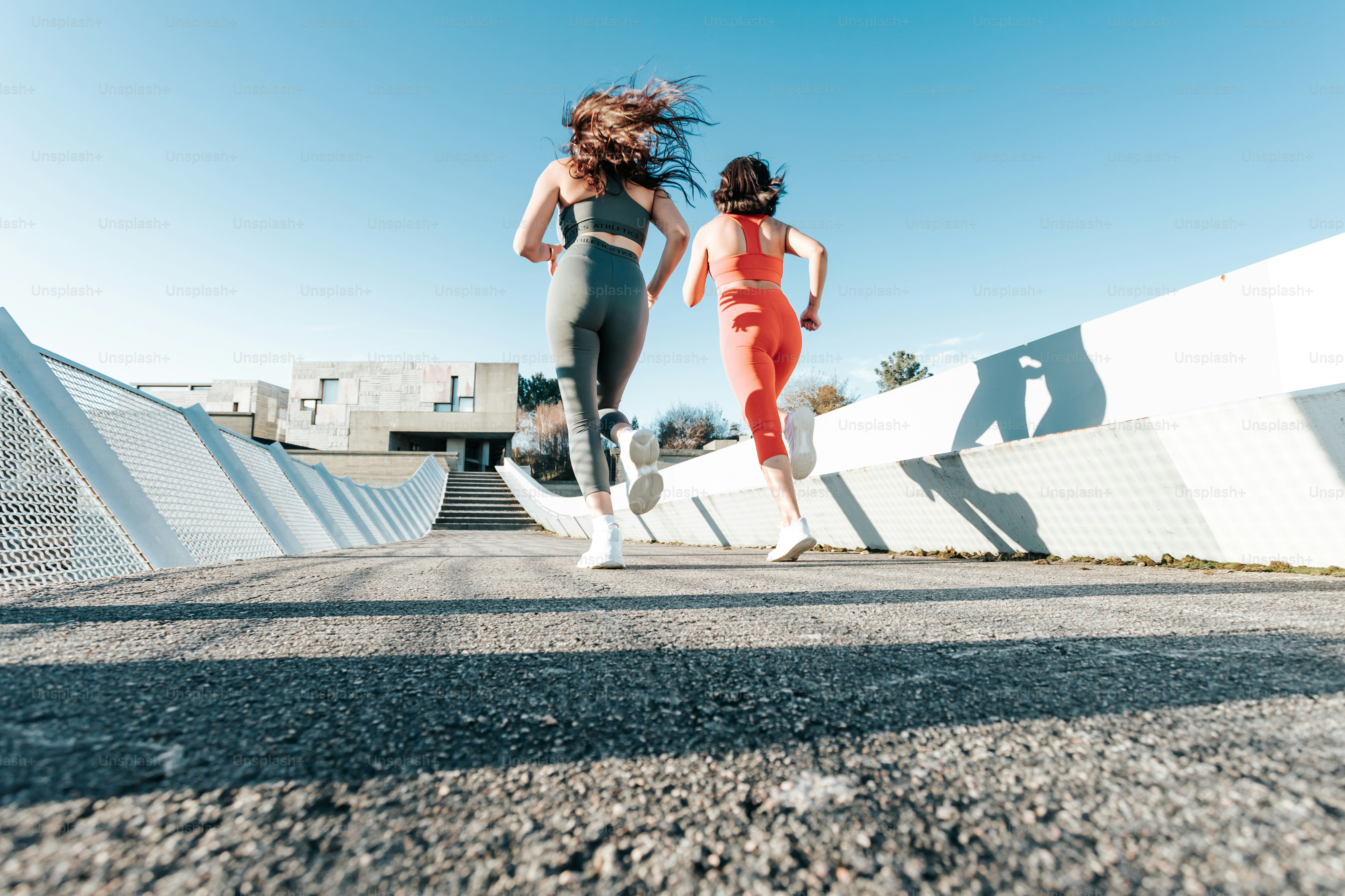 A woman running down a street next to a ramp photo – Jog Image on Unsplash