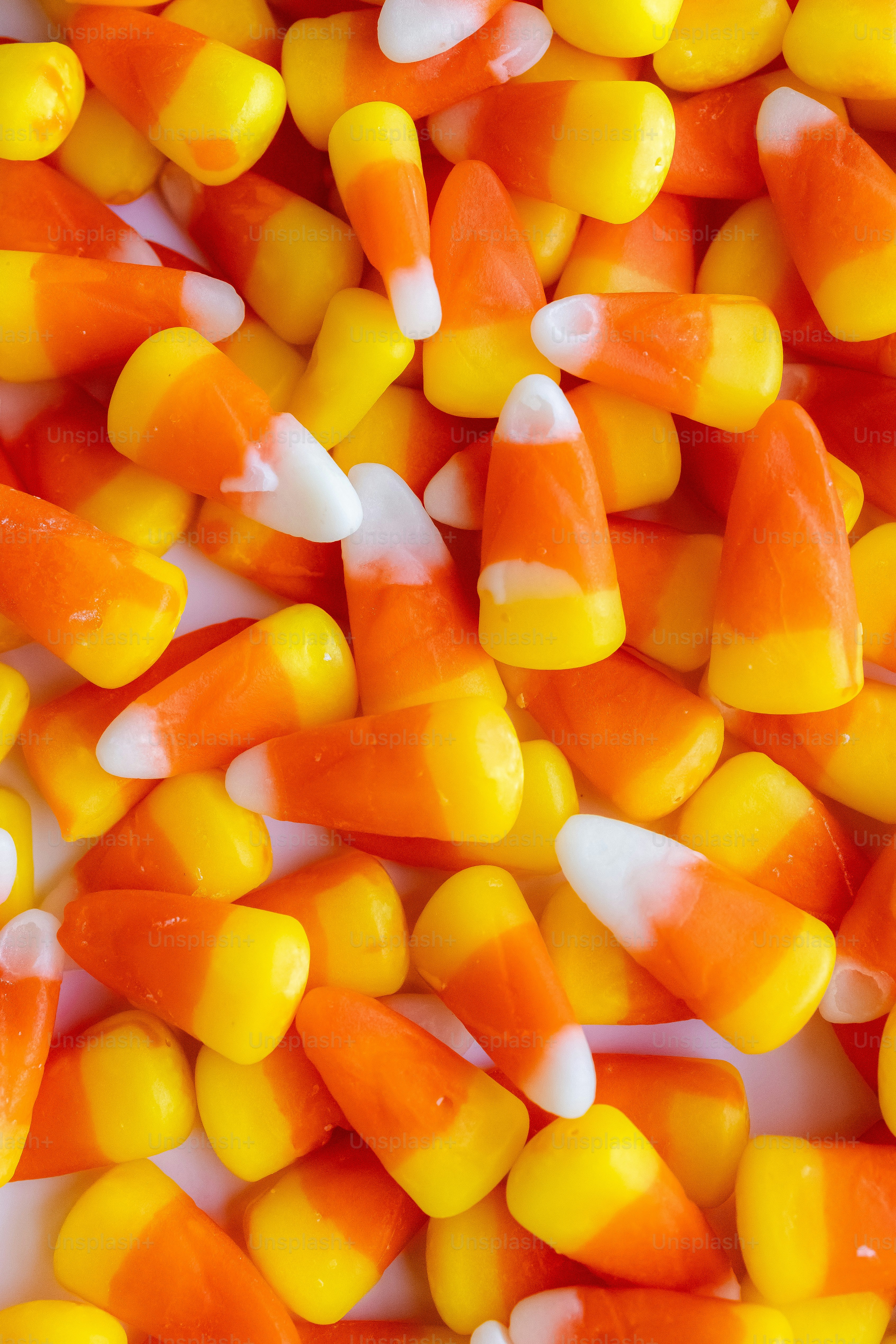 A pile of orange and yellow candy corn photo – Candy background Image ...