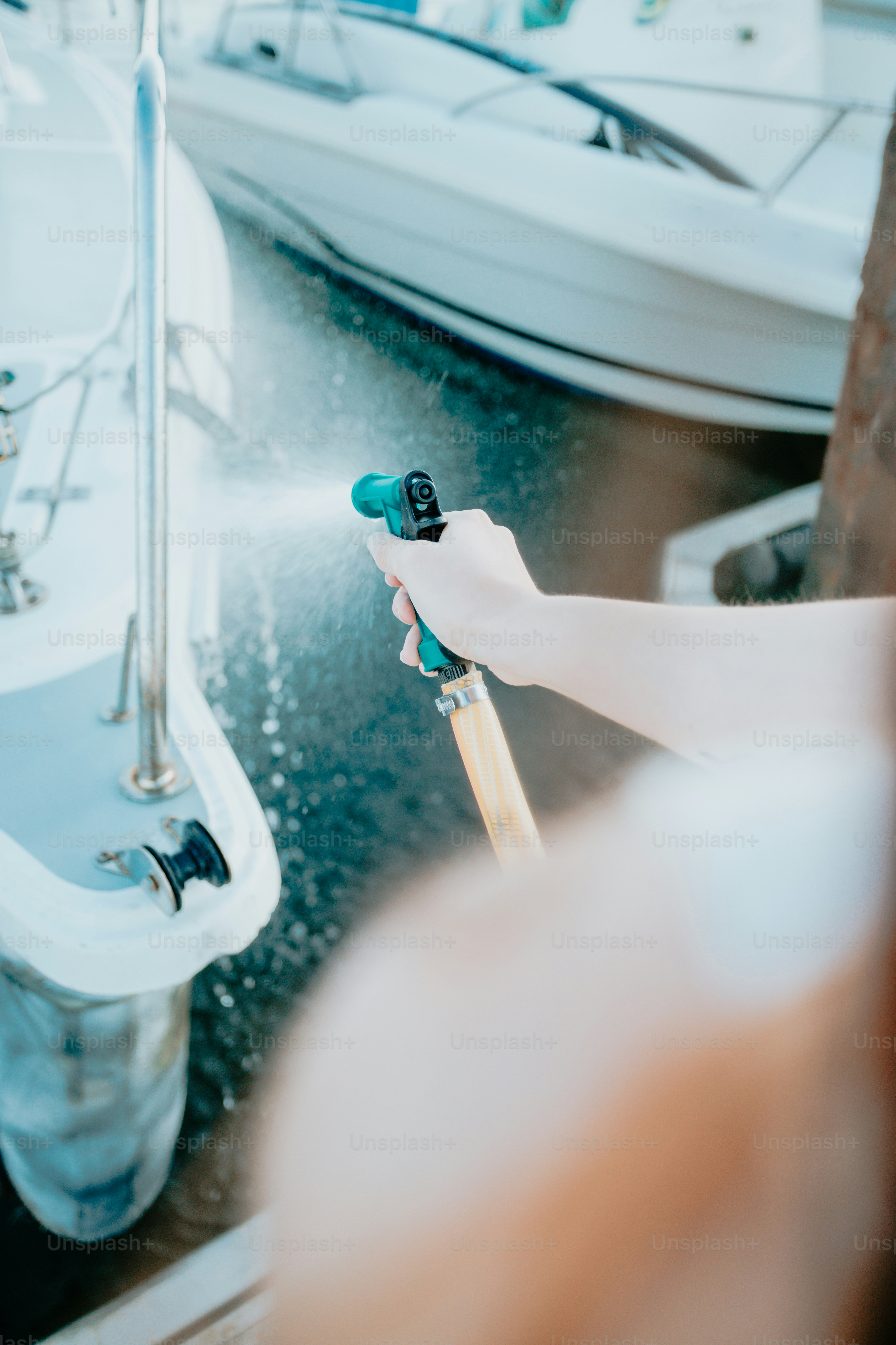A person spraying a boat with a sprayer photo – Sailing Image on Unsplash