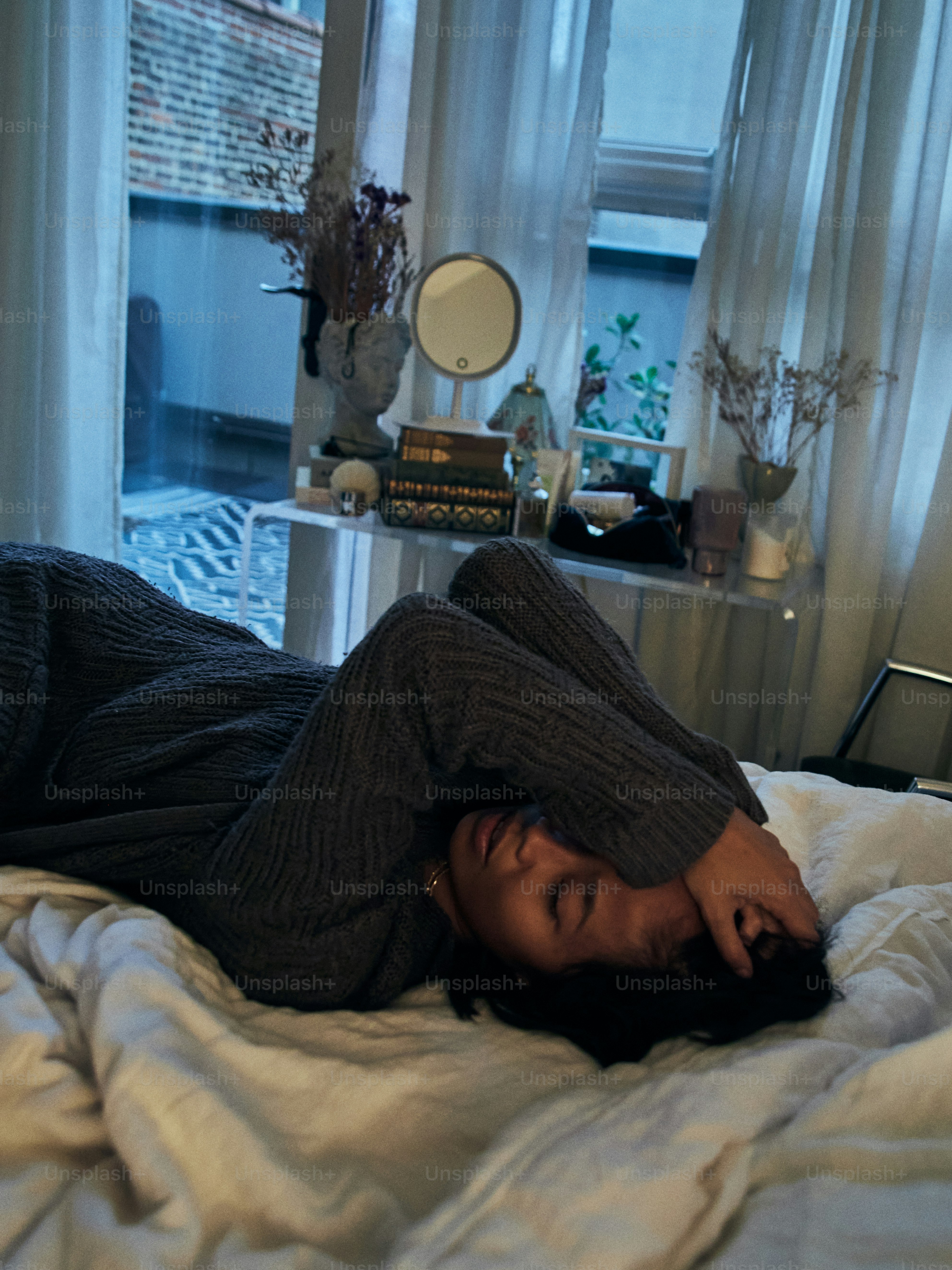 A woman laying on a bed with her legs crossed photo – Depression Image ...