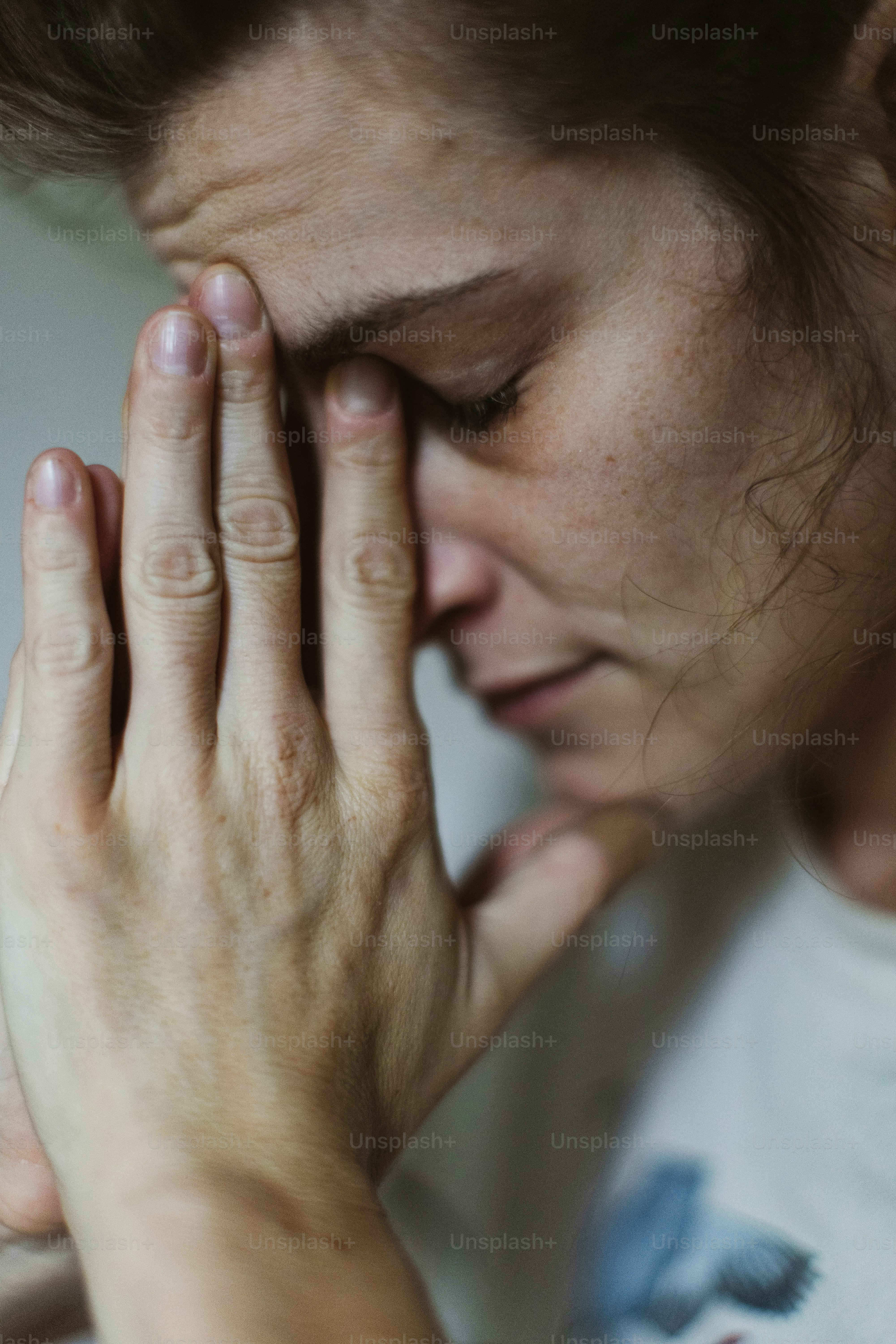 A woman holding her hand to her face photo – Sad woman Image on Unsplash