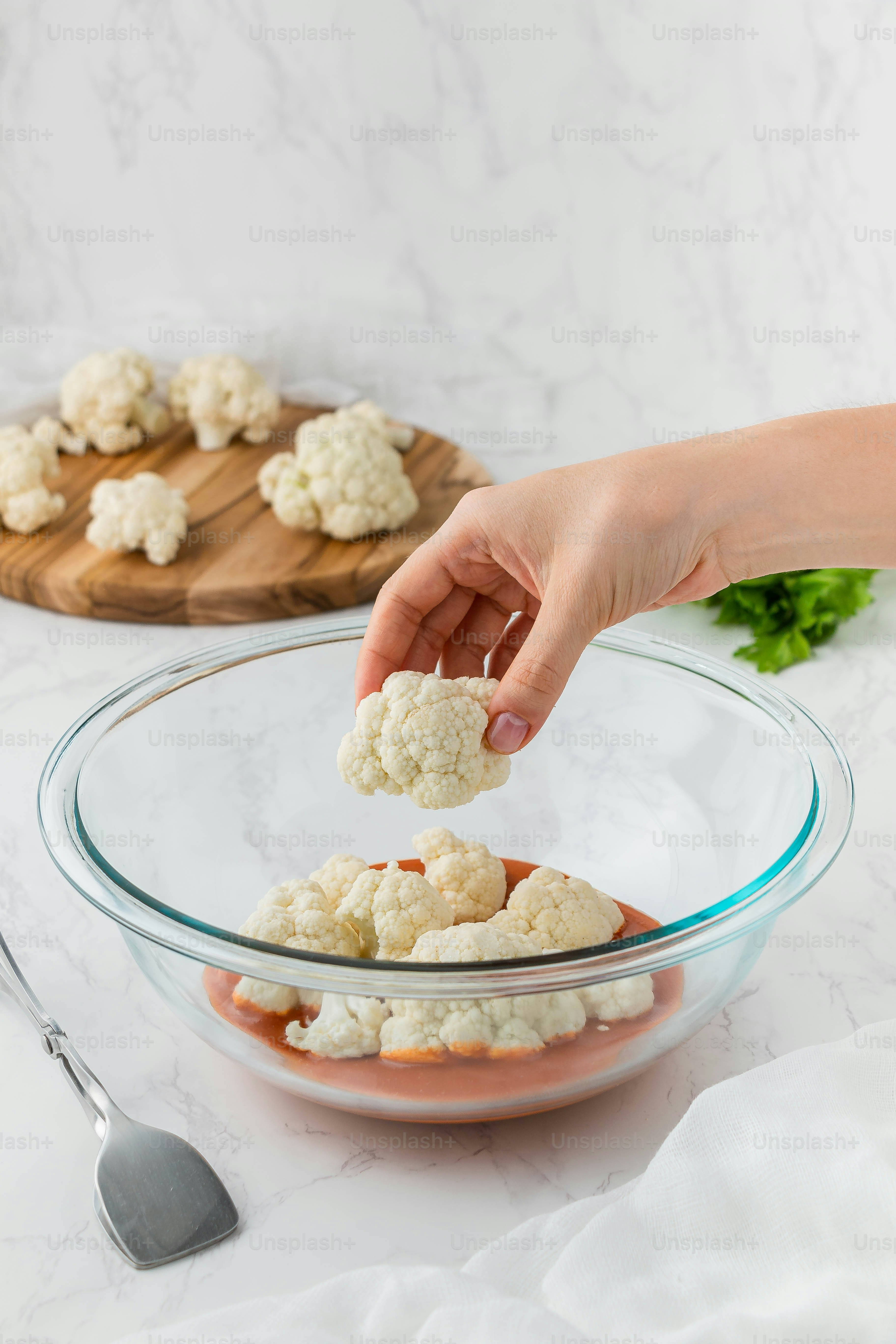 A person scooping cauliflower into a bowl photo – Vegetarian Image on ...