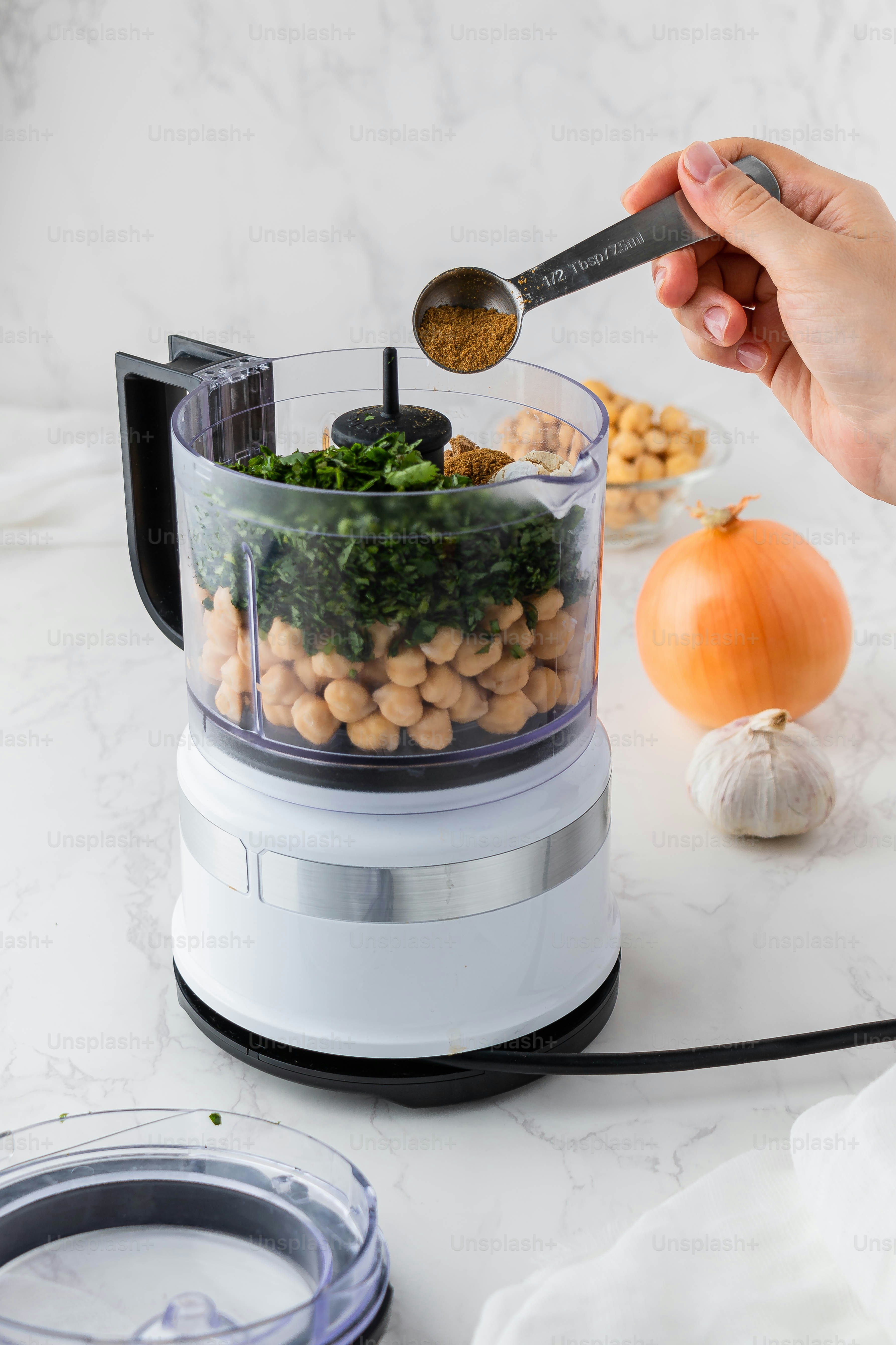 A person using a food processor to make a meal photo – Chickpea Image ...