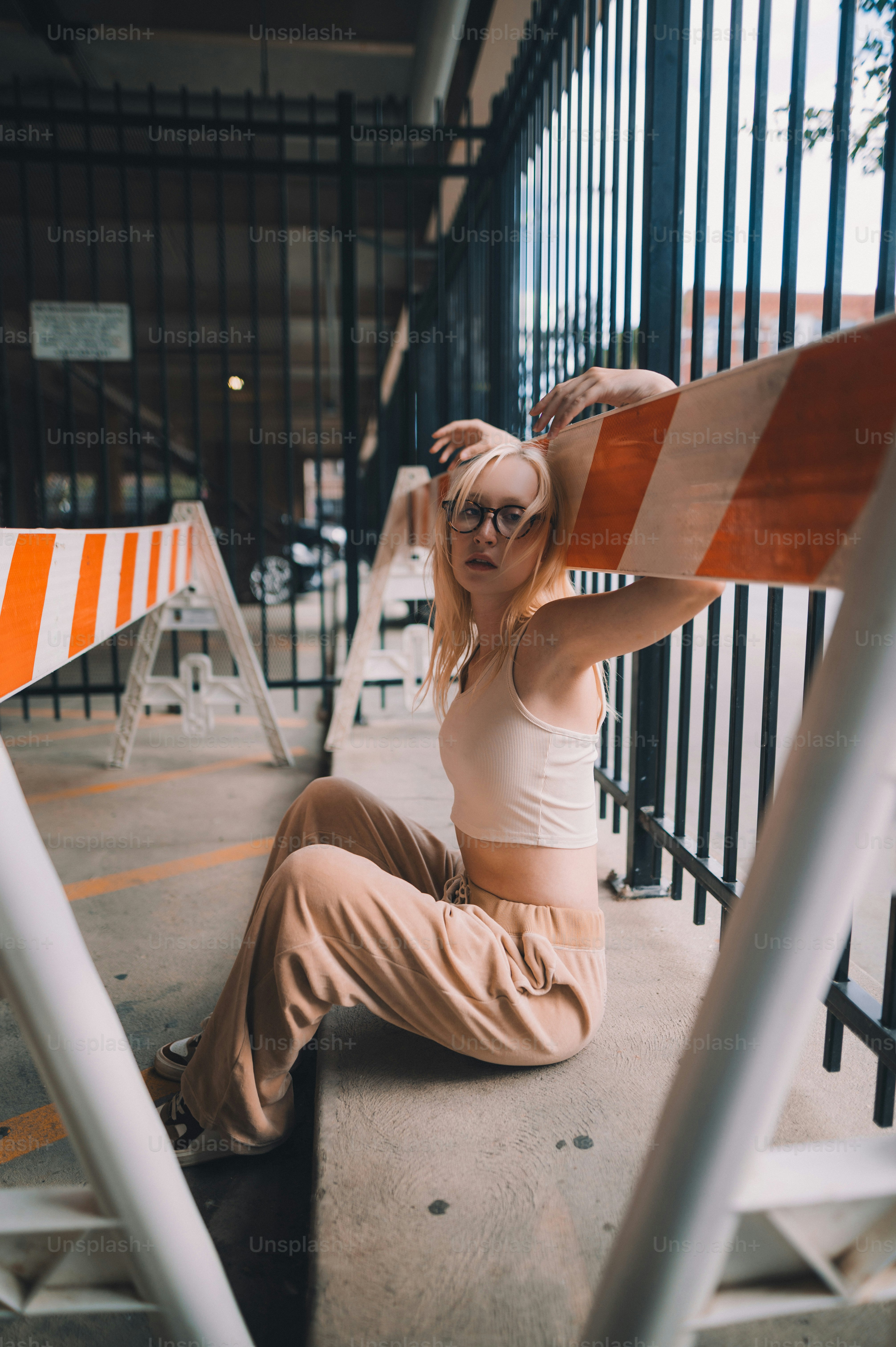 A woman sitting on the ground next to a barricade photo – Gen-z Image ...