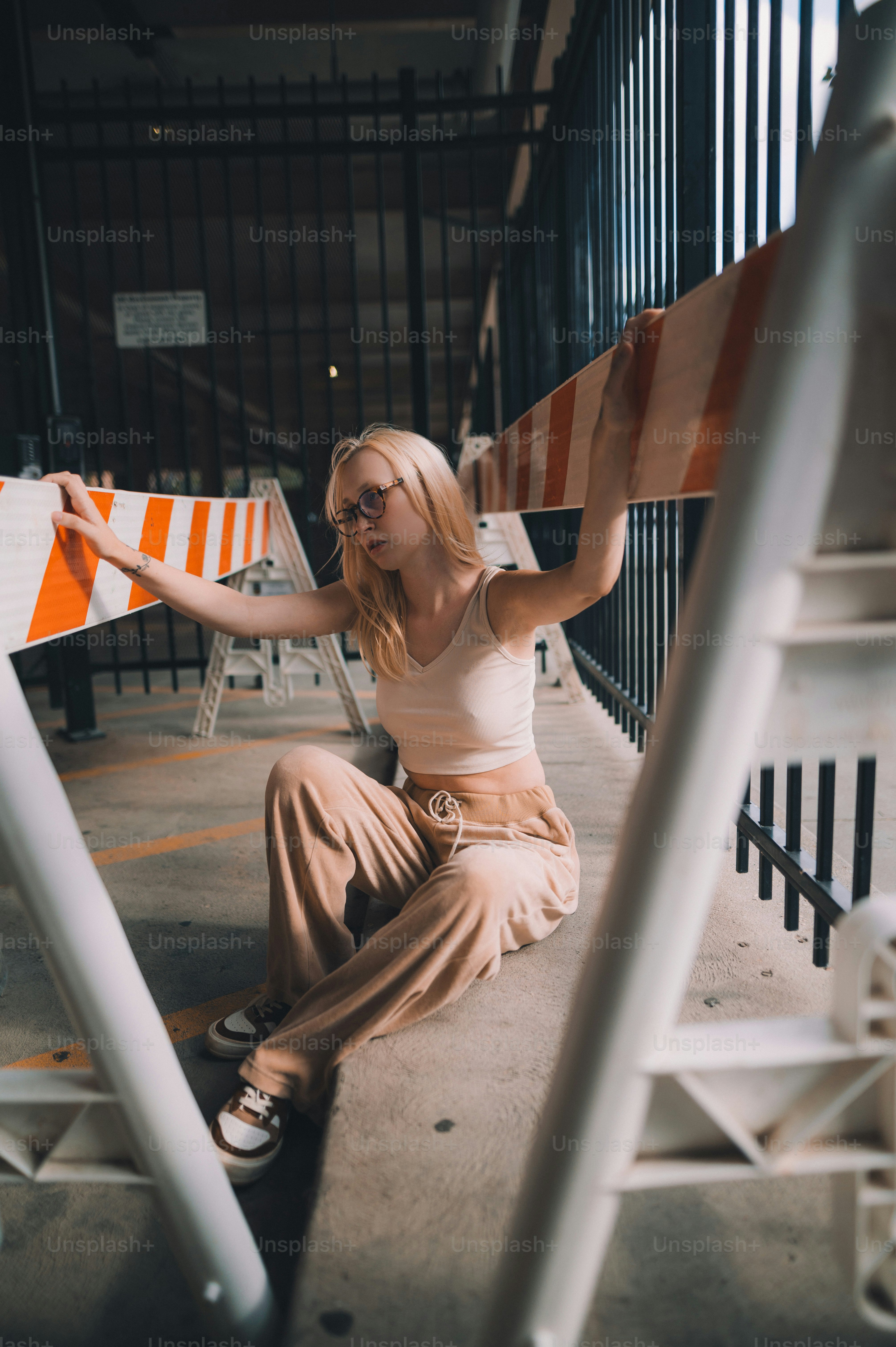 A woman sitting on the ground holding a sign photo – Construction site ...