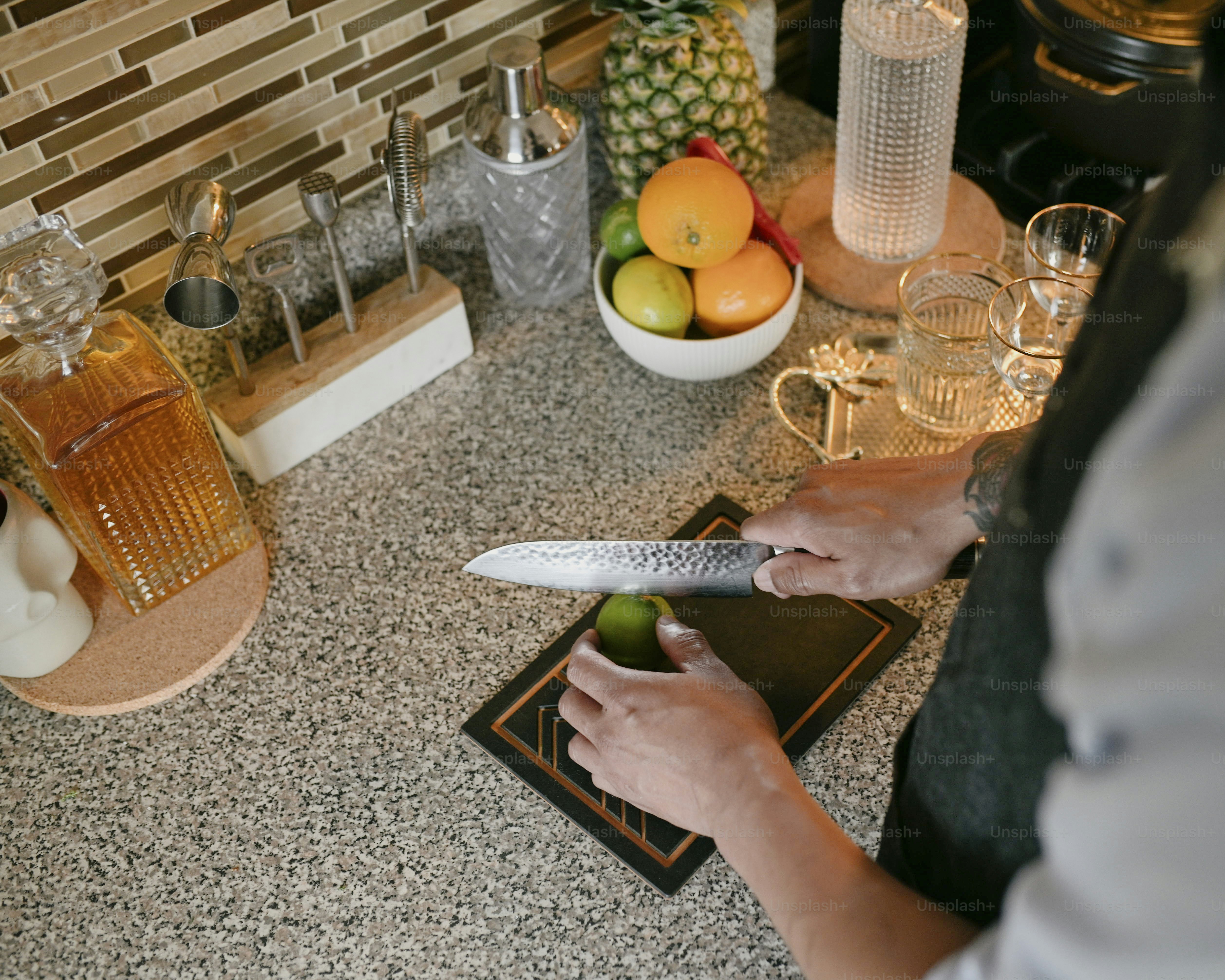 Foto Una persona cortando una fruta en una tabla de cortar – Picando ...