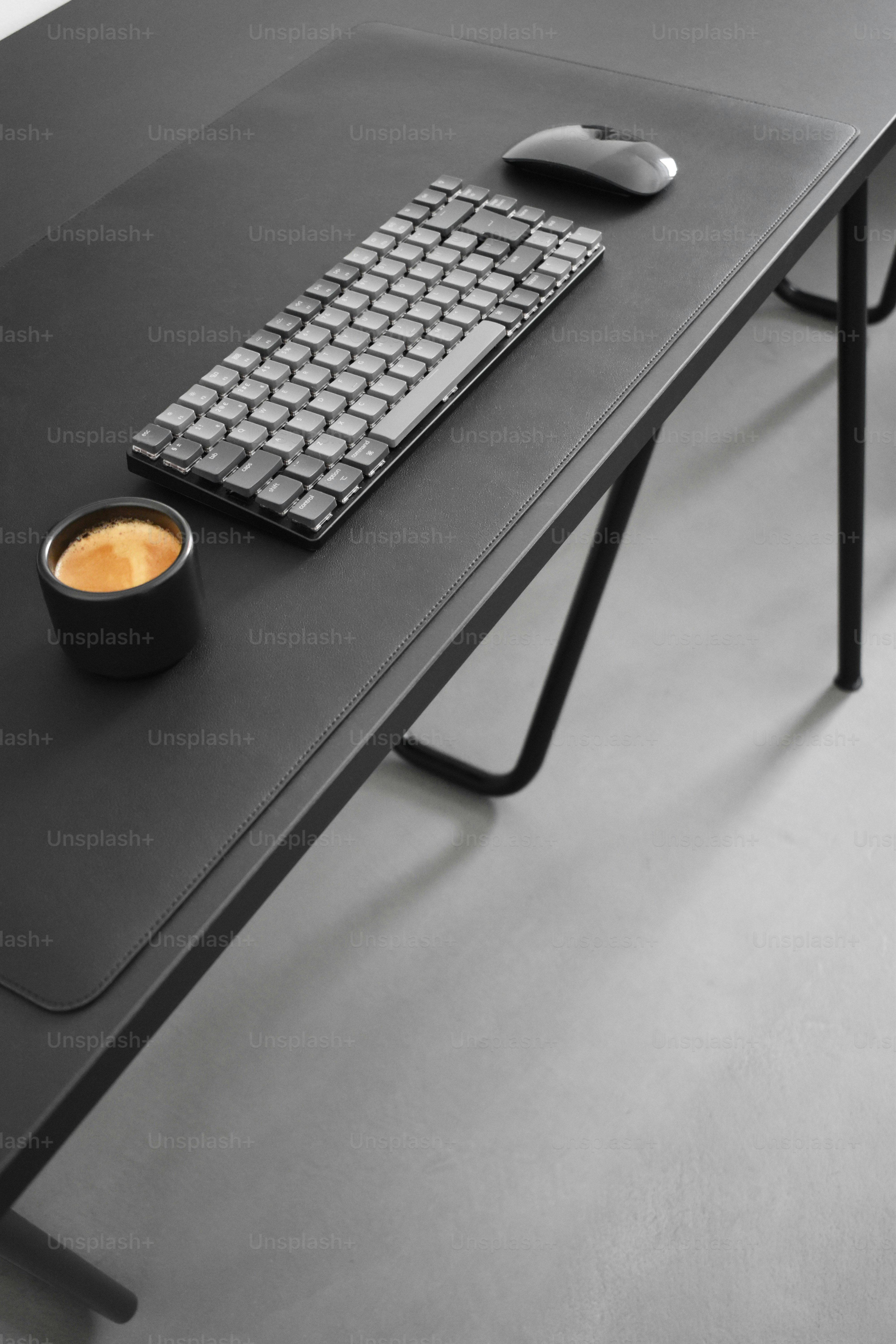A computer desk with a keyboard, mouse and cup of coffee photo ...