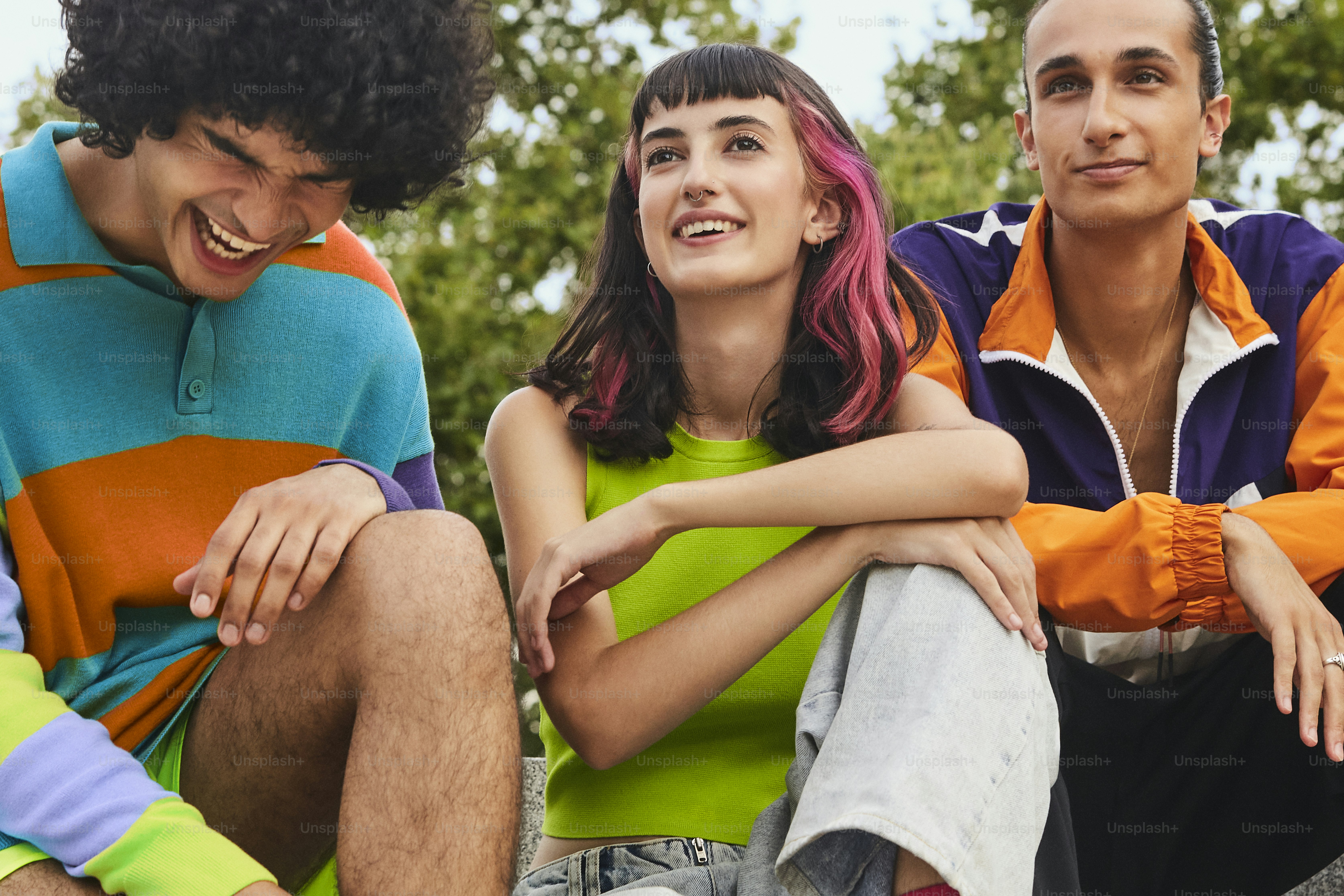 A group of young people sitting next to each other photo – Confident ...