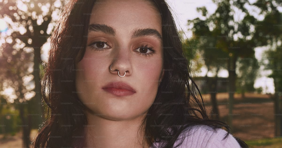 Une Femme Avec Un Piercing Au Nez Assise Dans Lherbe Photo Fille