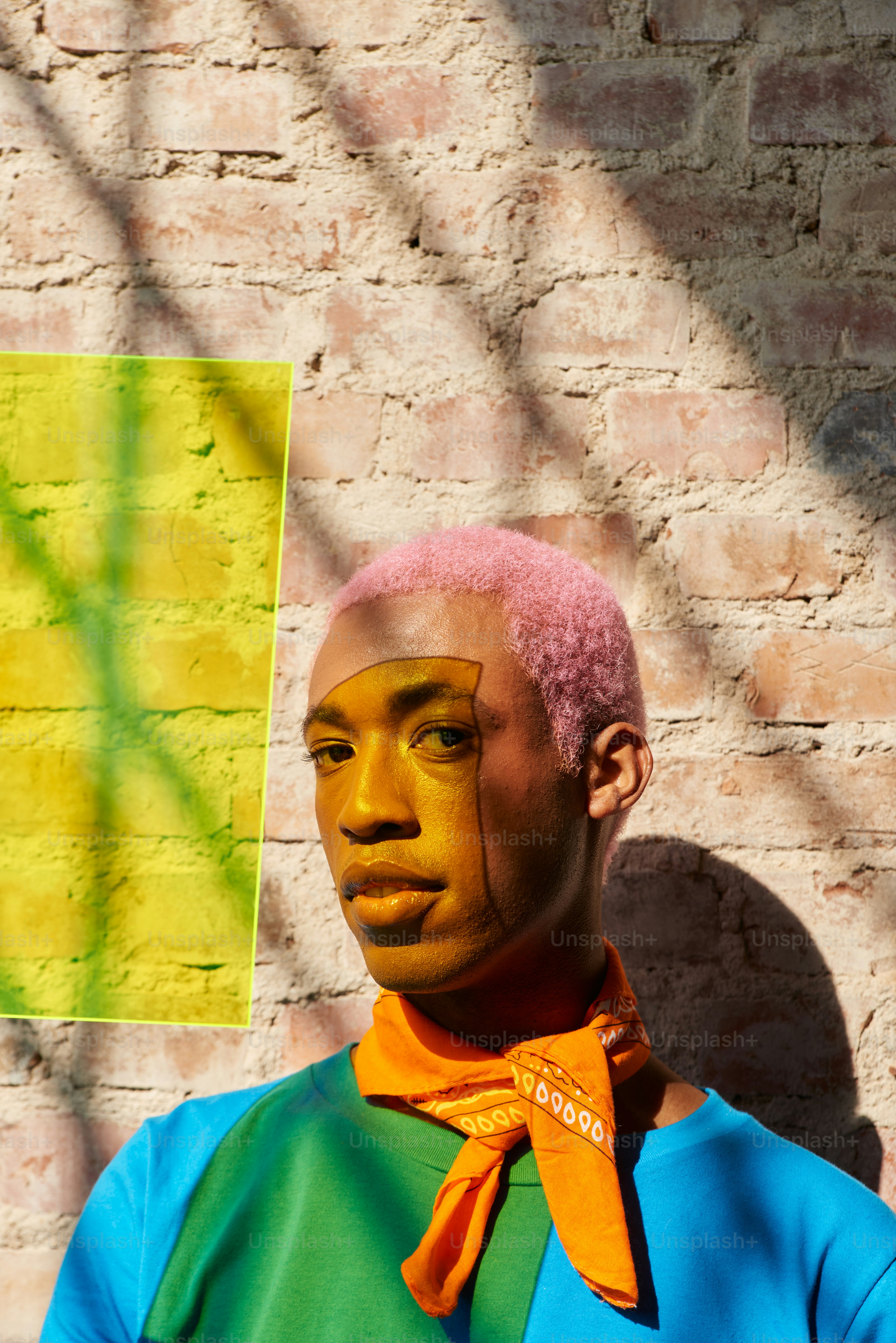 Foto Un hombre con cabello rosado parado frente a una pared de ...