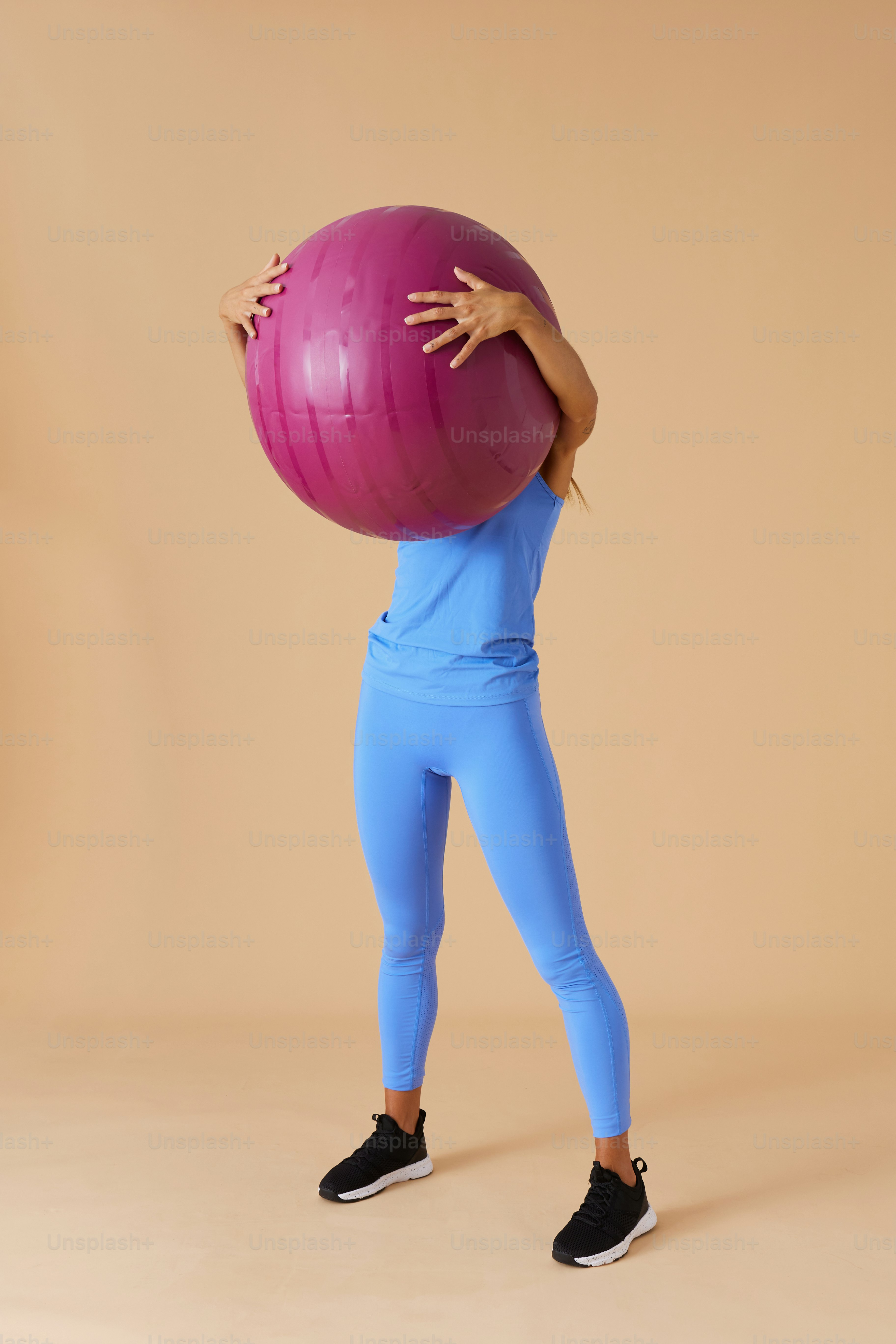A woman is holding a large exercise ball photo – Sports wear Image on ...