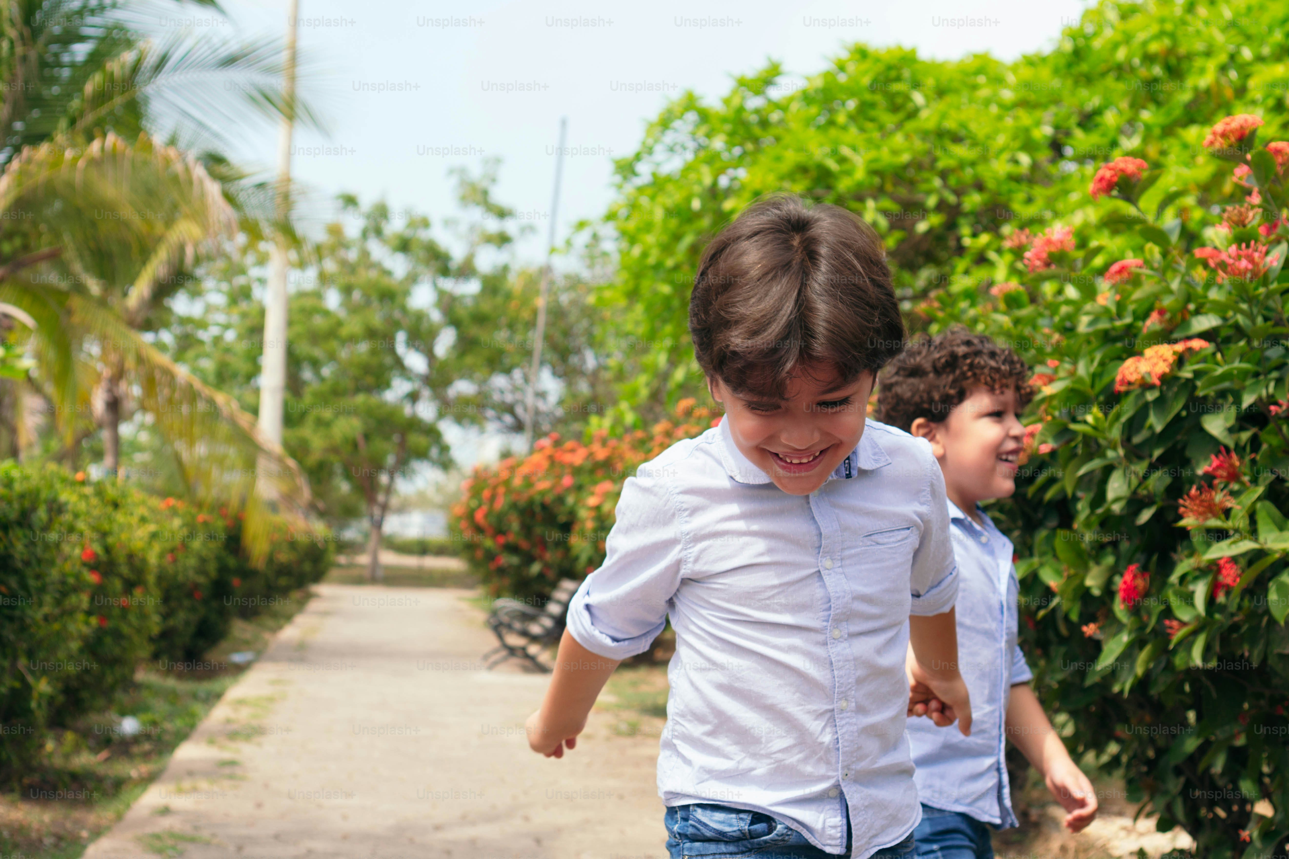 Two Hispanic brothers walking in the park photo – Togetherness Image on ...