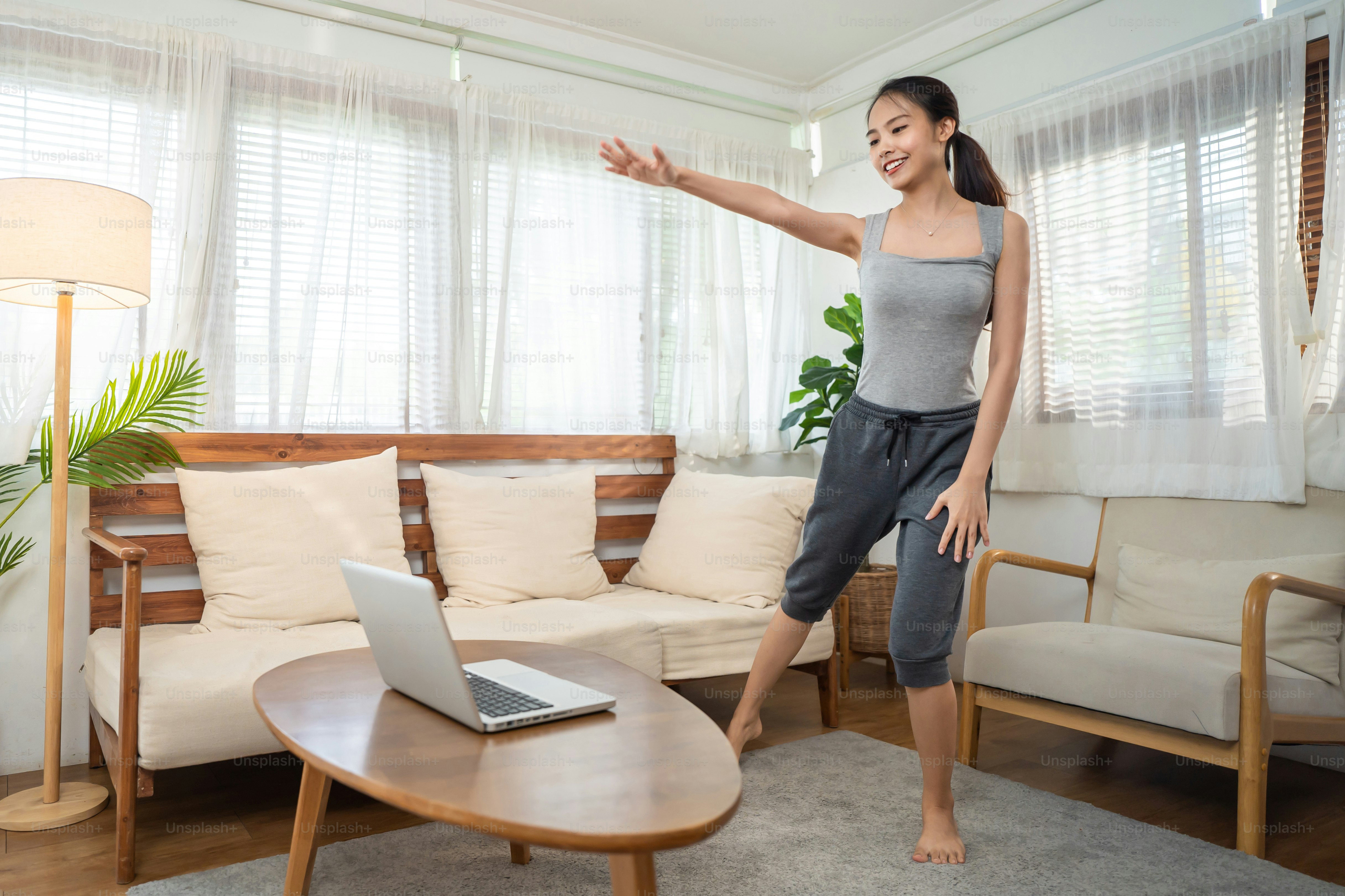 Asian young girl doing Yoga, follow online trainer in laptop at home. Active Beautiful ...