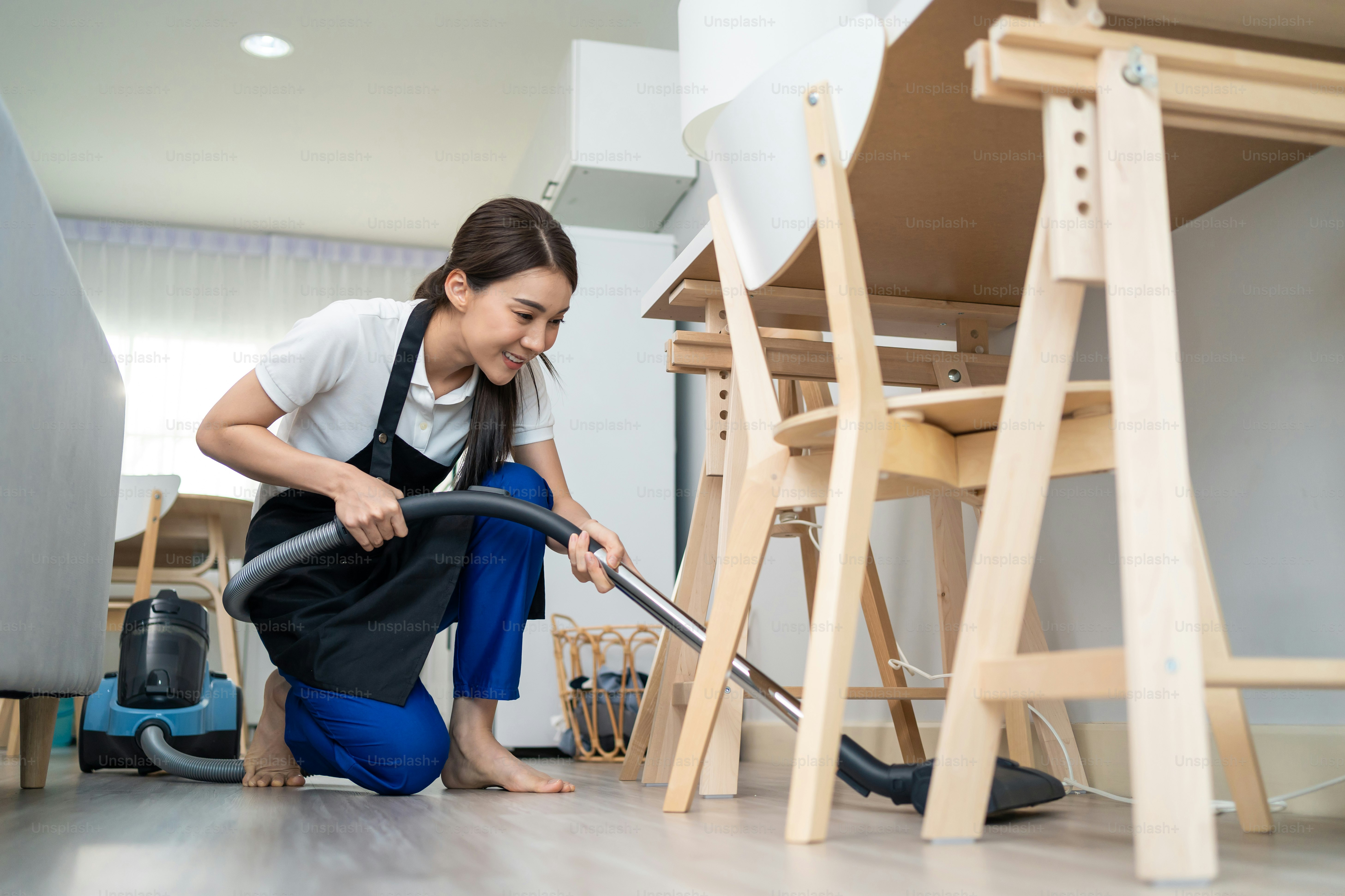 Asian cleaning service woman worker cleaning in living room at home. Beautiful young girl ...
