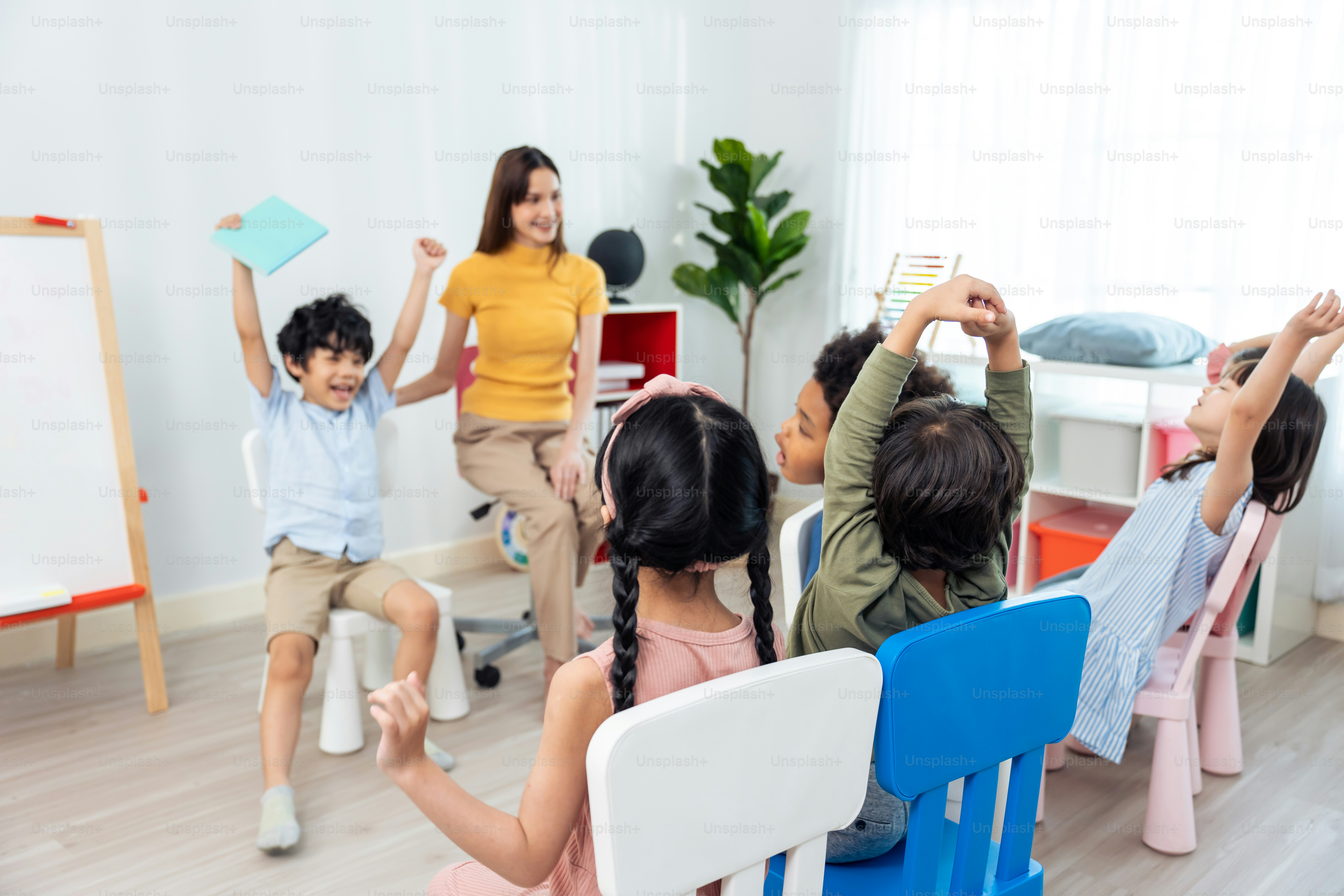 Caucasian beautiful woman teacher teaching a lesson to kid at school. Attractive female ...