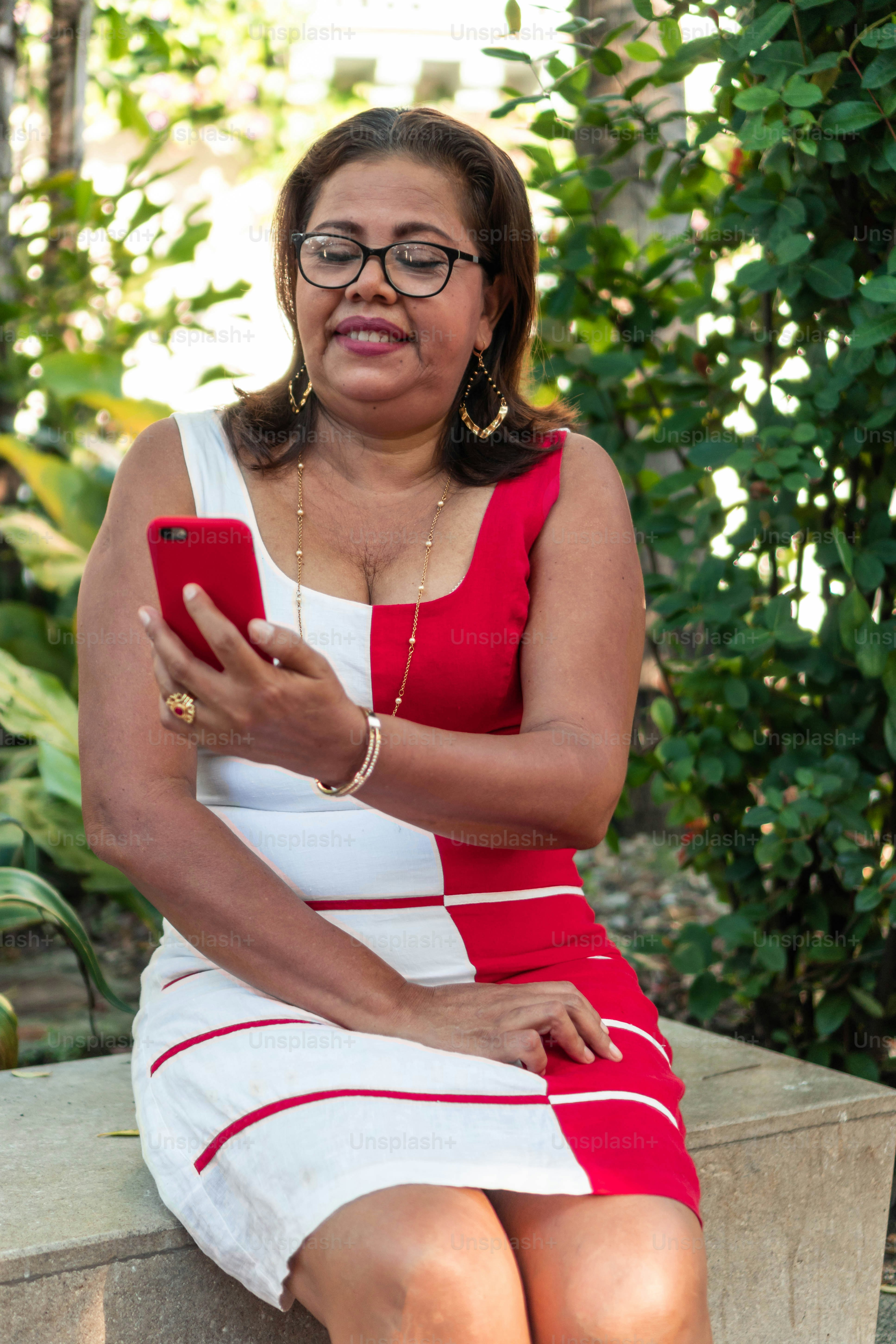 Foto Mujer mayor sonriente atractiva que envía mensajes de texto o ...