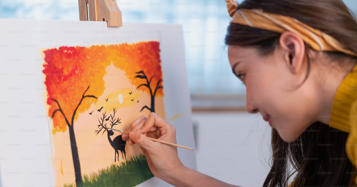 아시아의 젊은 재능 있는 여성 예술가가 집에서 그림 보드에 색칠하고 있다 매력적인 아름다운 여성은 수채화 물감과 브러시로 예술