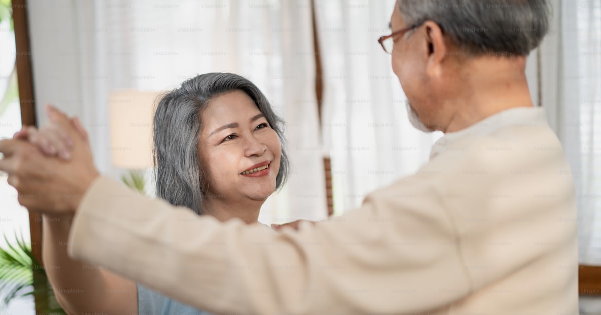 아시아의 행복한 노인 부부는 집에 머물며 거실에서 여가 시간을 보낸다 할아버지와 할머니는 은퇴 생활과 함께 춤을 즐깁니다